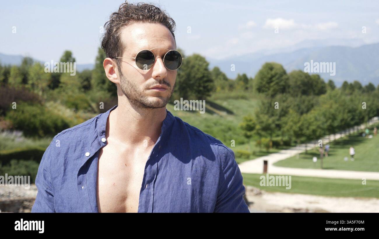 Handsome muscular man posing in European luxury garden in Turin, Italy ...