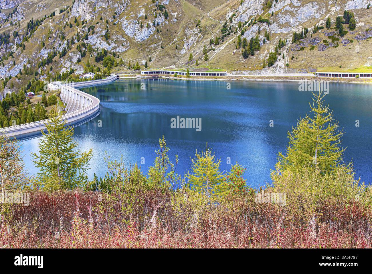 The grand dam raises the water level in the lake. Lago di Fedaya. Mount ...