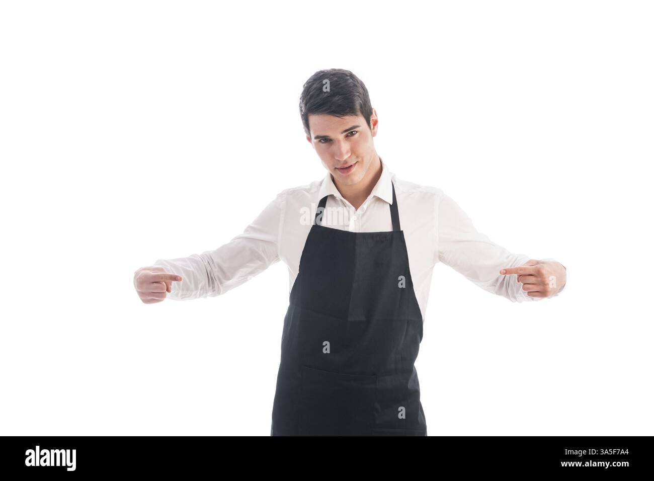 Young chef or waiter posing, wearing black apron and white shirt ...