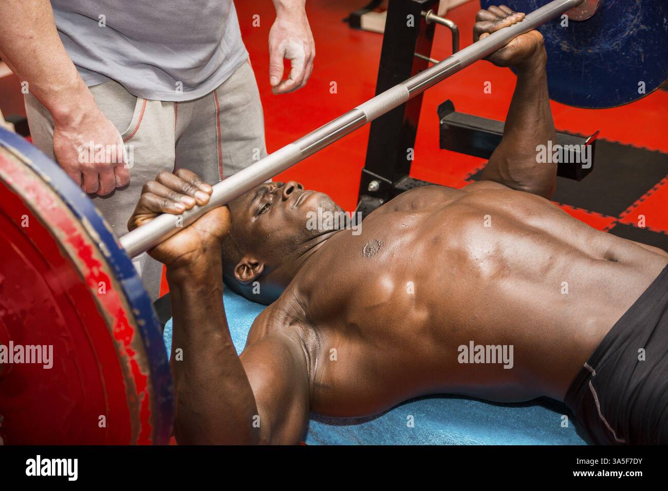 Hunky muscular black bodybuilder working out in gym, exercising pecs on ...