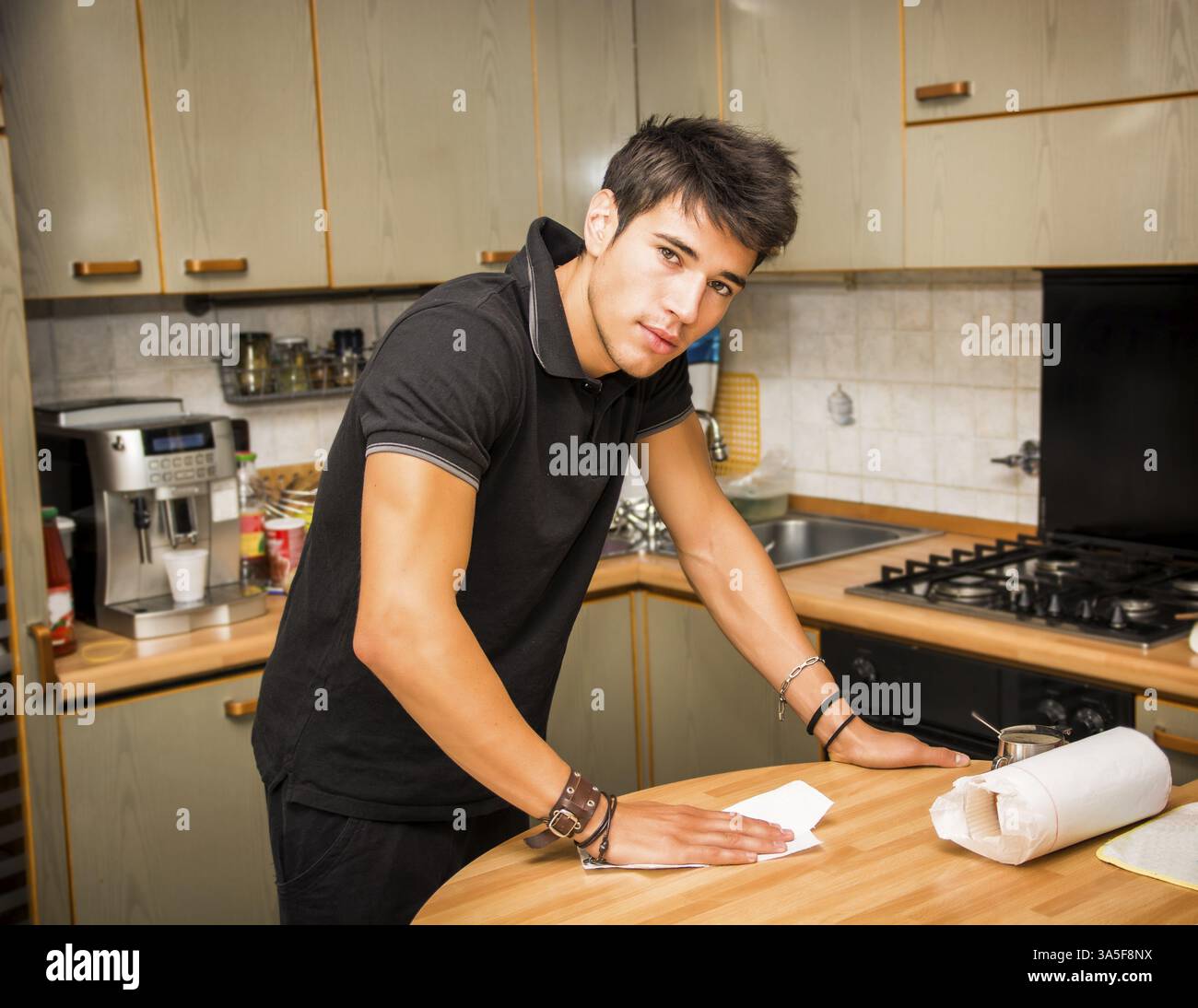 Attractive Young Man with Dark Hair, Looking at Camera While Cleaning ...