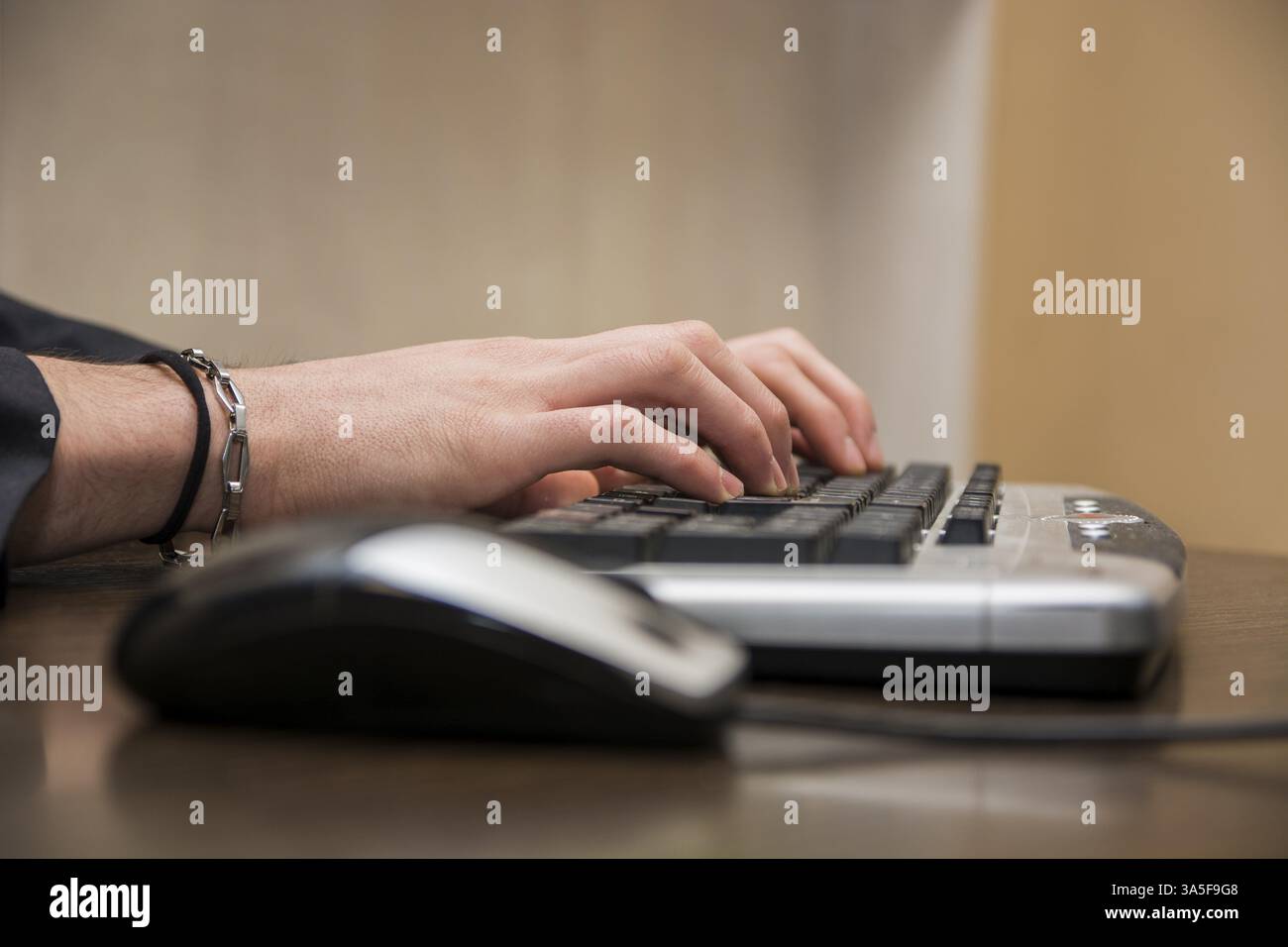 Hand of a man working at computer typing on keyboard in his office, on ...