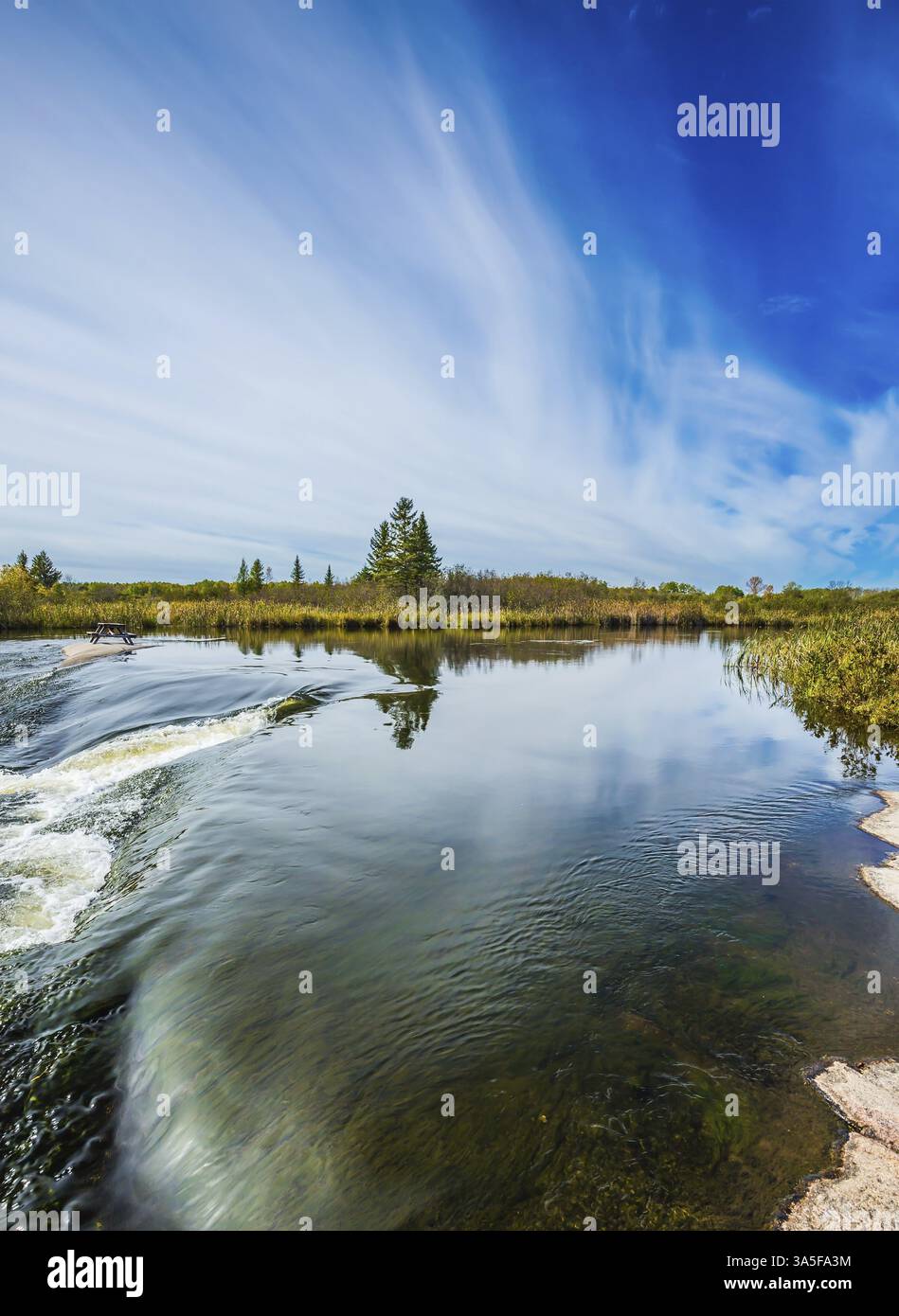 Waterfall drain on the smooth stones of the Winnipeg River. Old Pinawa ...