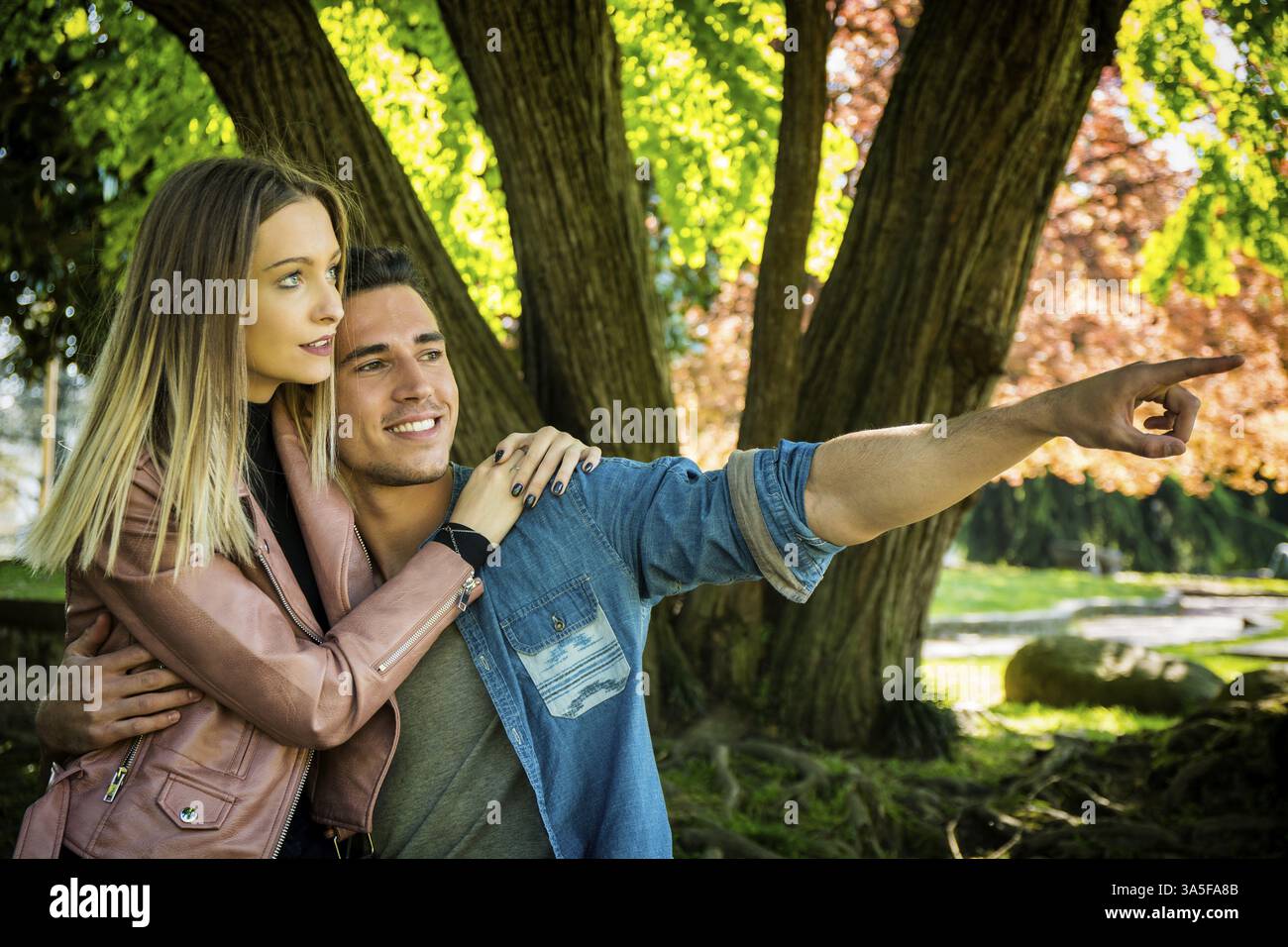 Boyfriend and girlfriend standing in countryside in green luscious ...