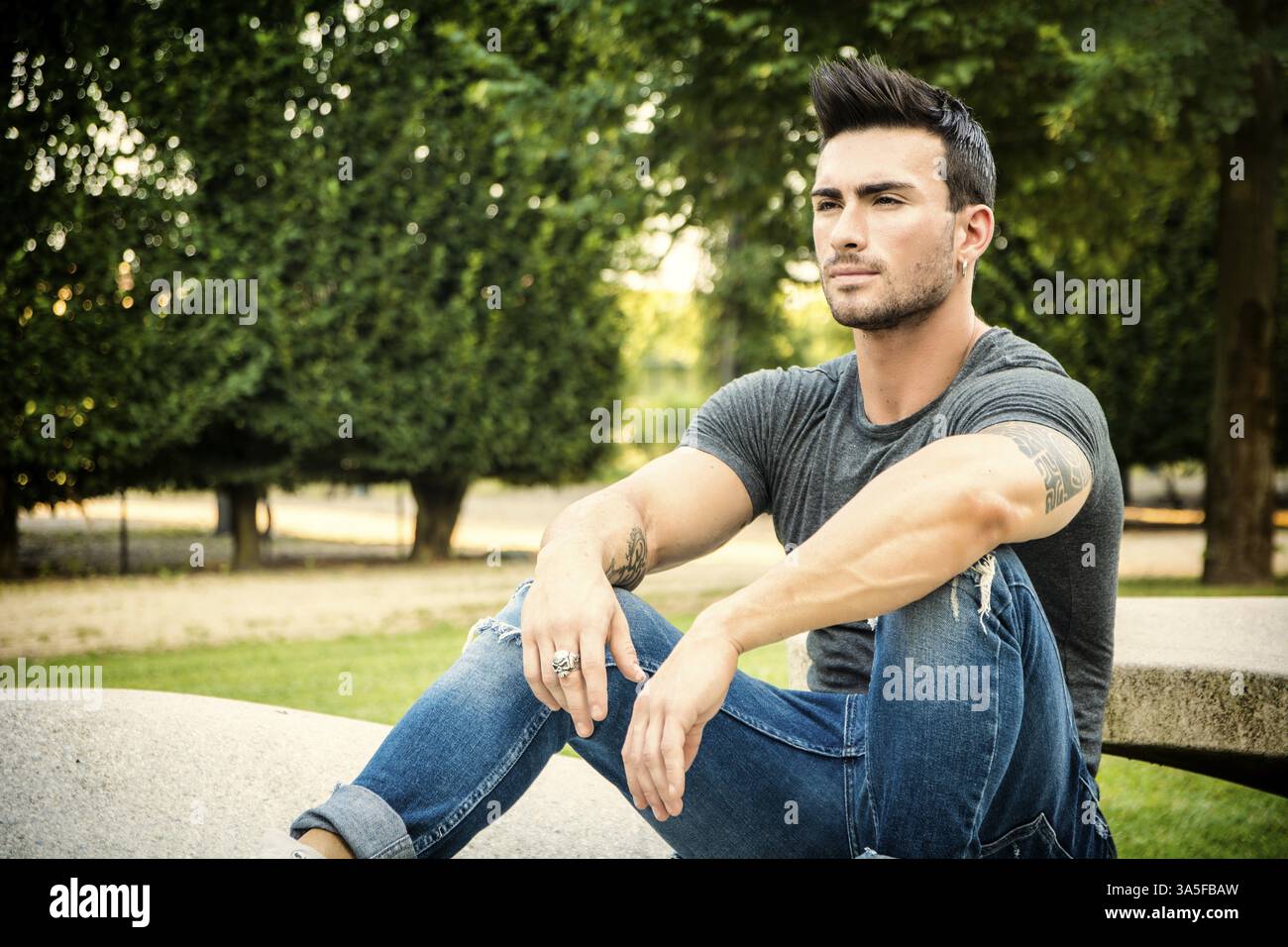 Handsome muscular man with tattoo posing in European luxury garden in ...