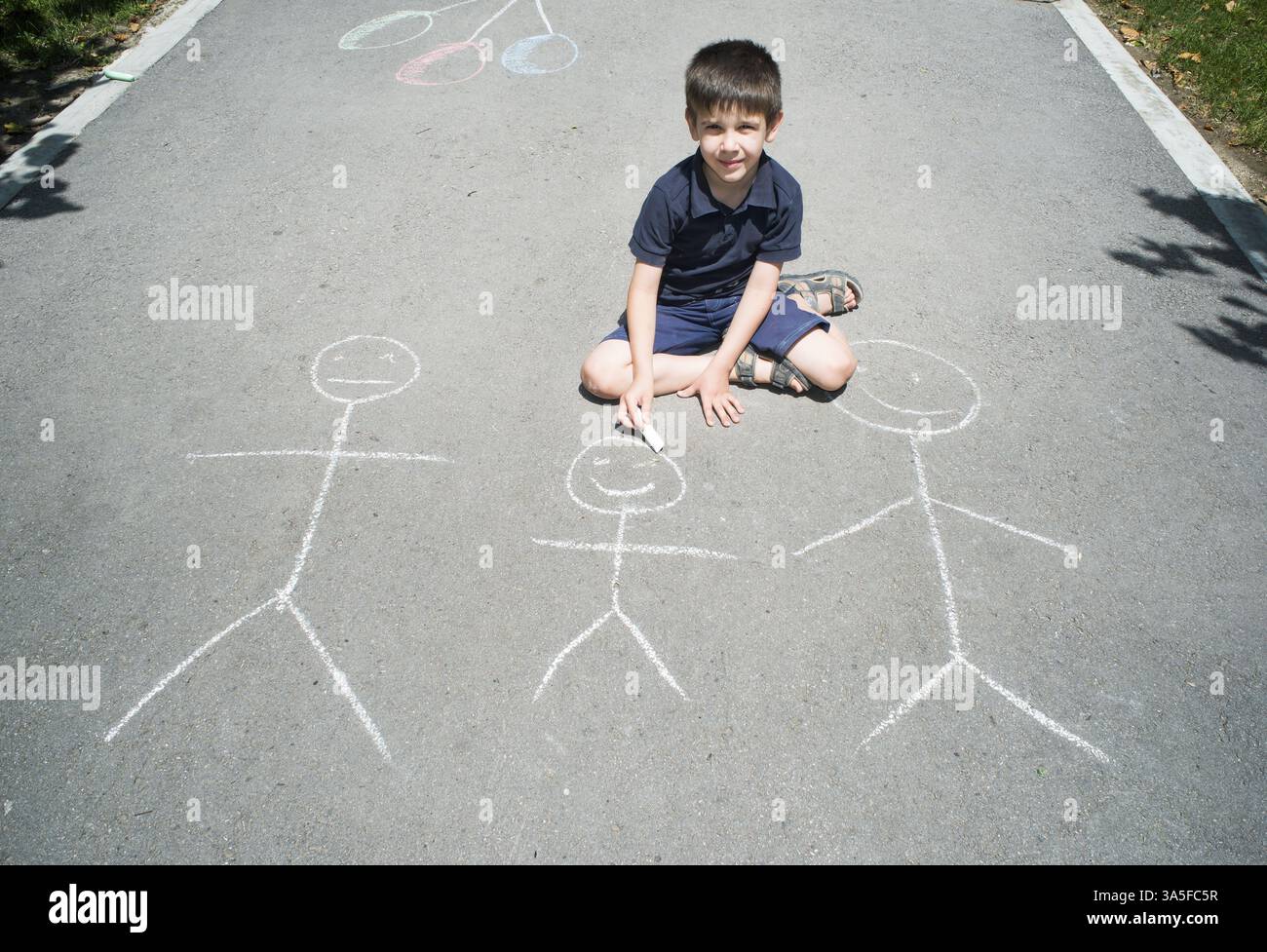 Child drawing family on asphalt in a park Stock Photo - Alamy
