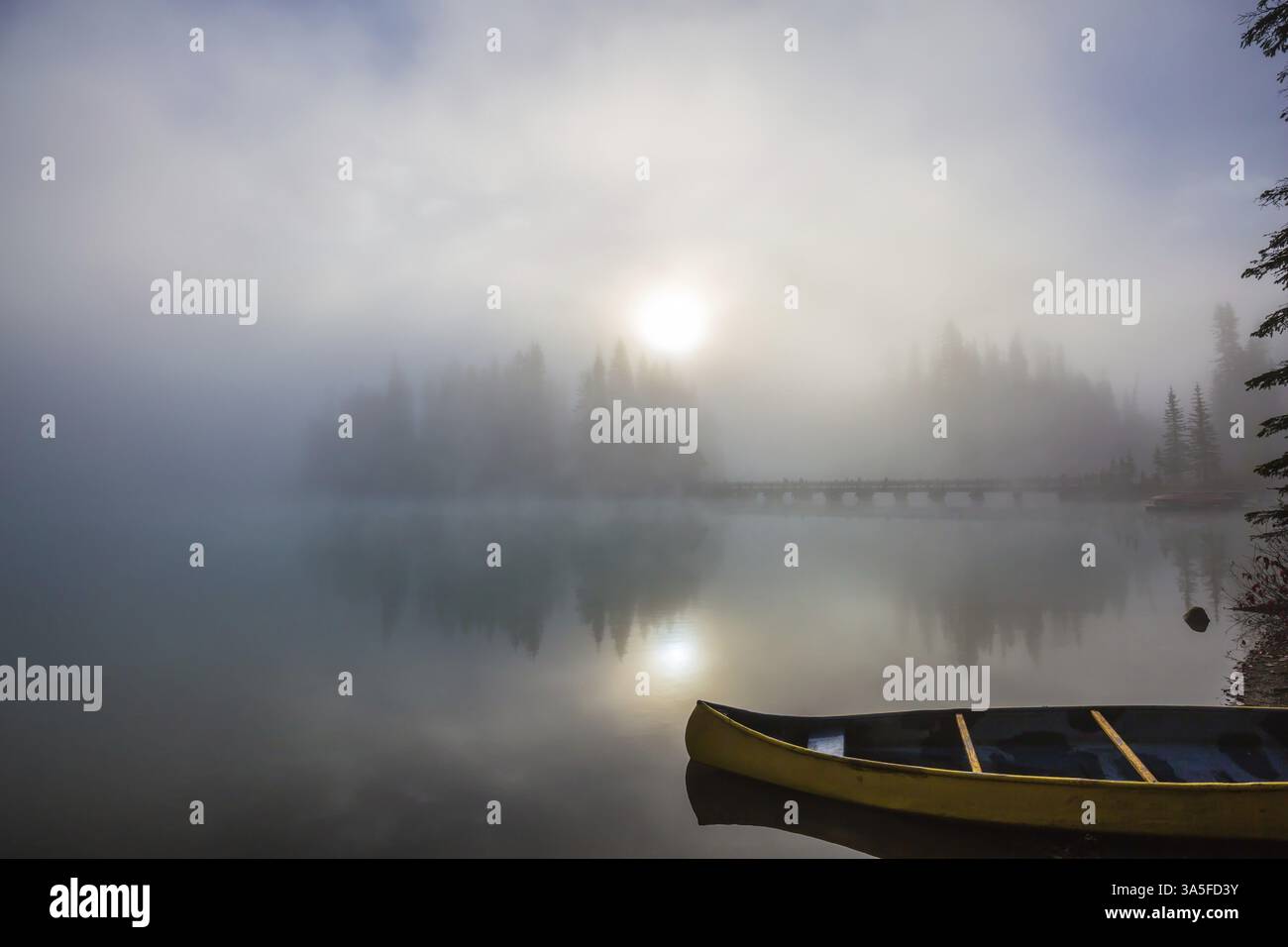 Emerald Lake in Yoho National Park. The sun peeps through the mist ...