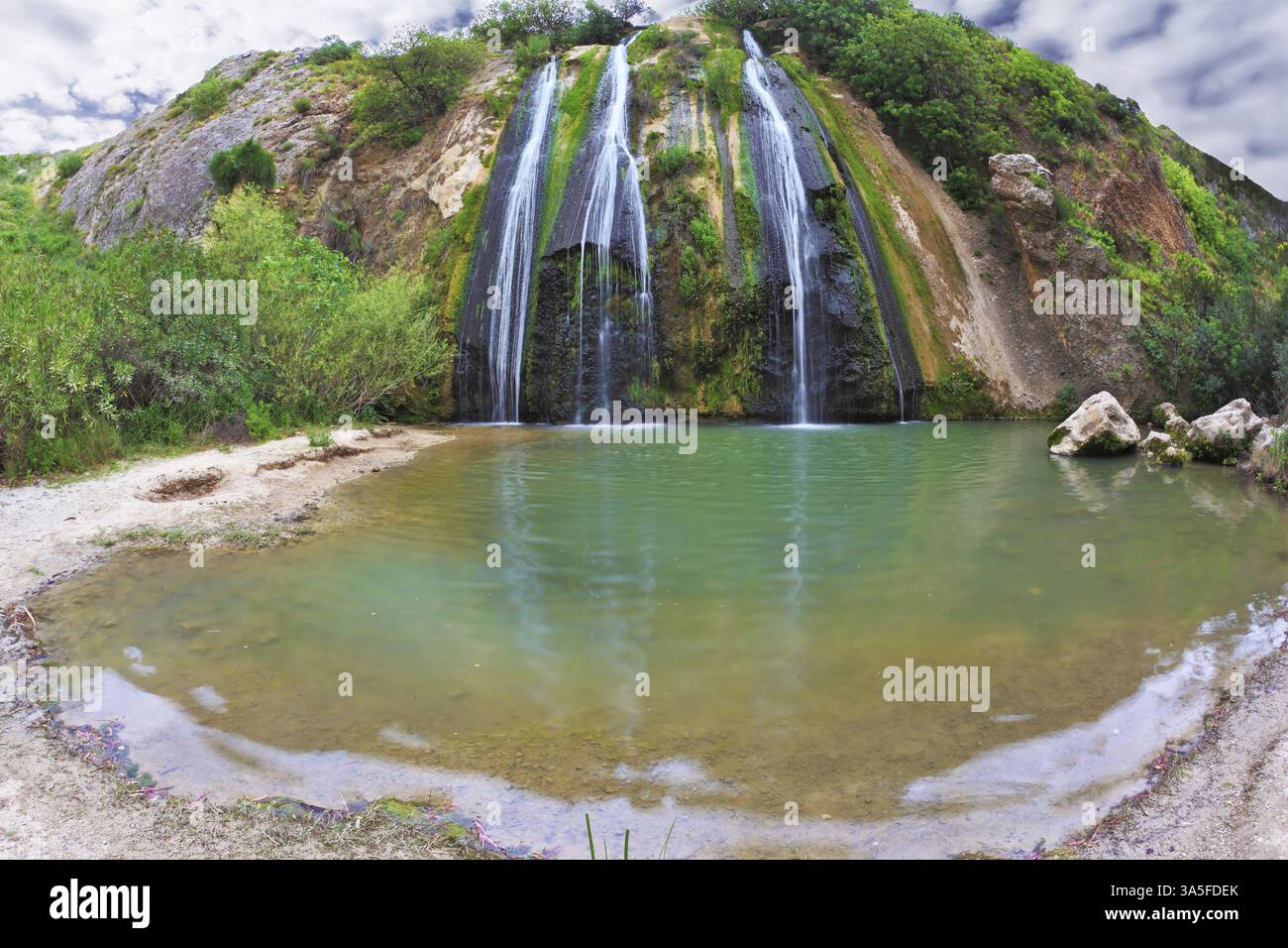 Three-jet scenic waterfall in the mountains. Three parallel streams of ...