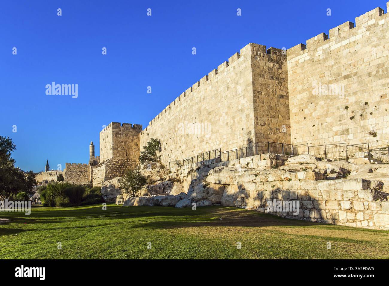 Adorable green lawn growing under ancient walls. Summer sunset. The ...