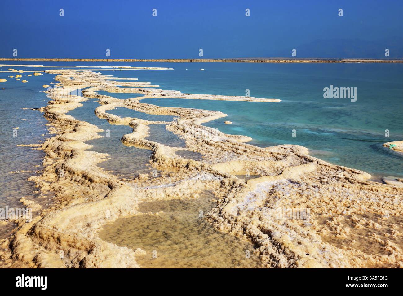 Path from the evaporated salt on a water surface. The Dead Sea at coast ...