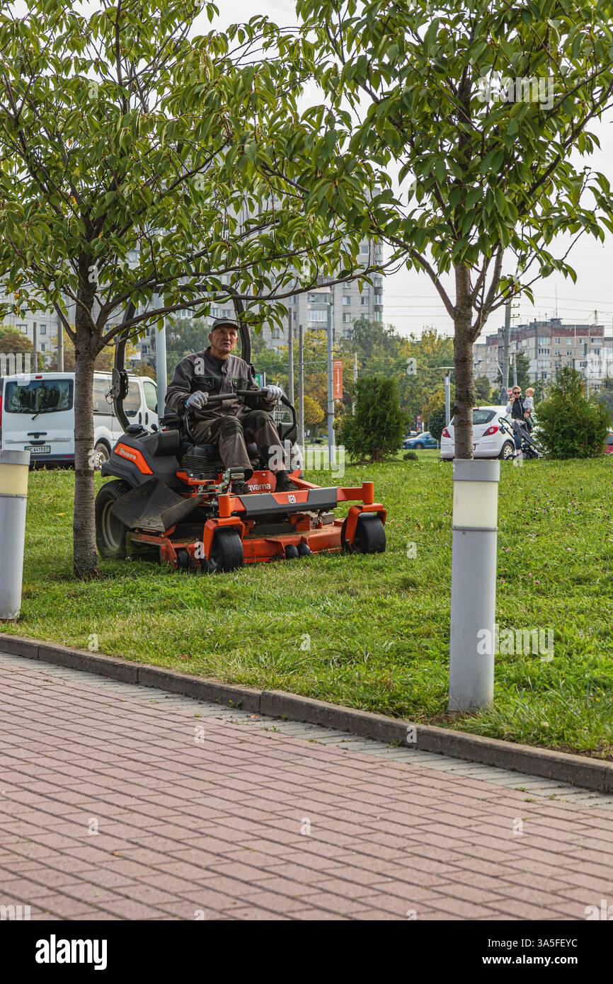 A lawn care worker mows the grass in a park area of Lviv, Ukraine. The ...