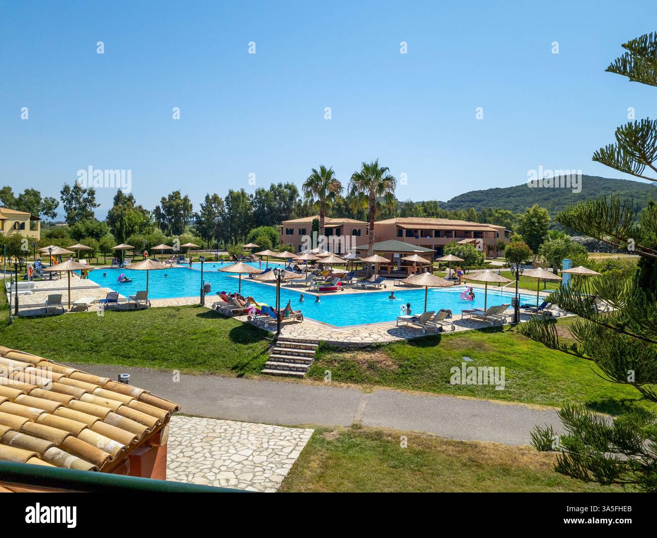 A vibrant pool scene under a clear blue sky, inviting relaxation amidst ...