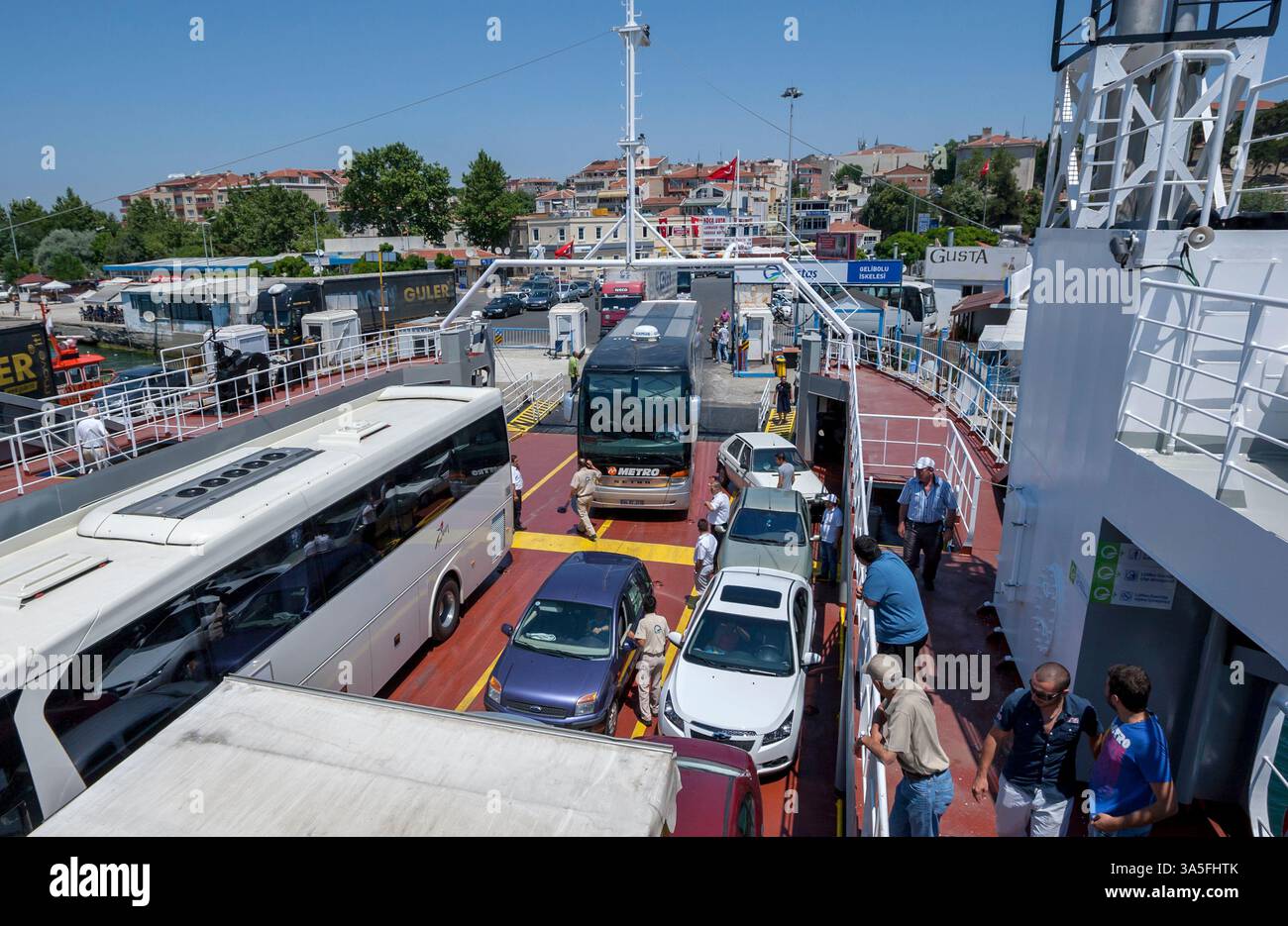 Buses and cars are loaded onto a ferry boat before crossing the ...