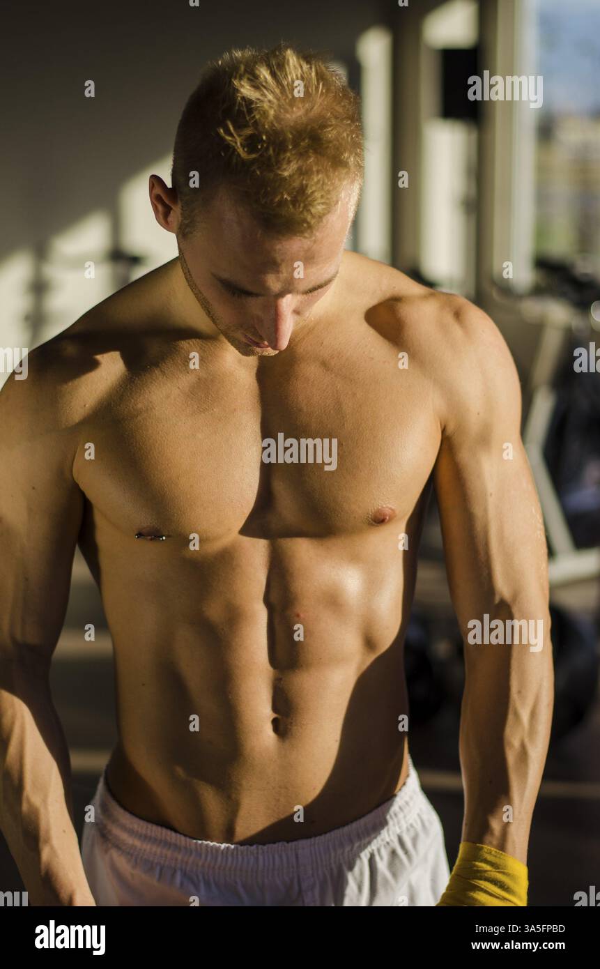 Muscular young man wrapping bandage around his hands for boxing Stock ...