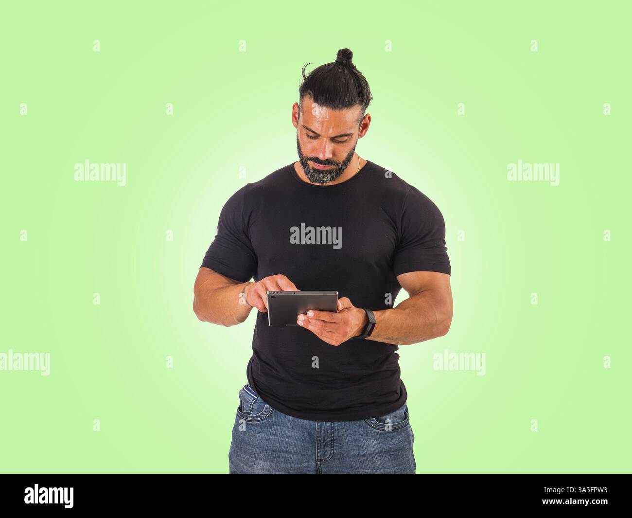 Attractive muscular man using electronic tablet, tapping on it ...