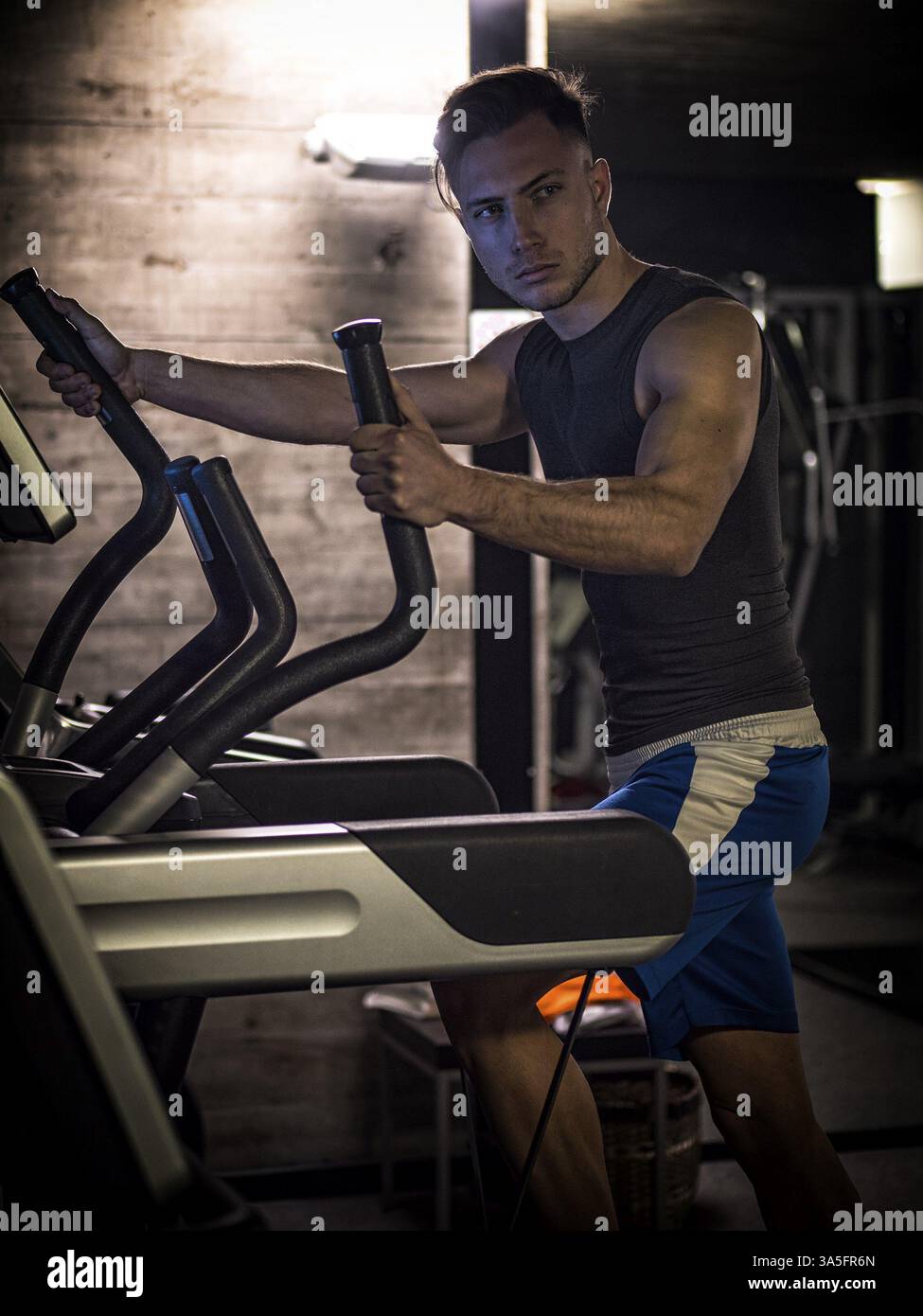 Muscular young man, training pecs on gym cable machine Stock Photo - Alamy