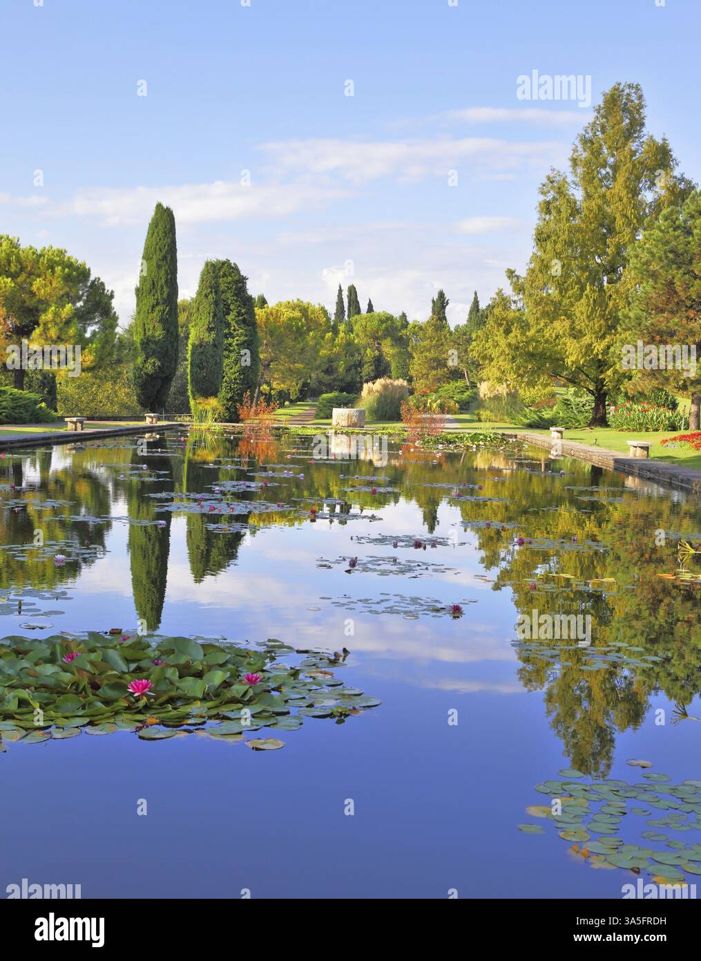 Magnificent Italian park at sunset. Smooth water of a pond reflects ...