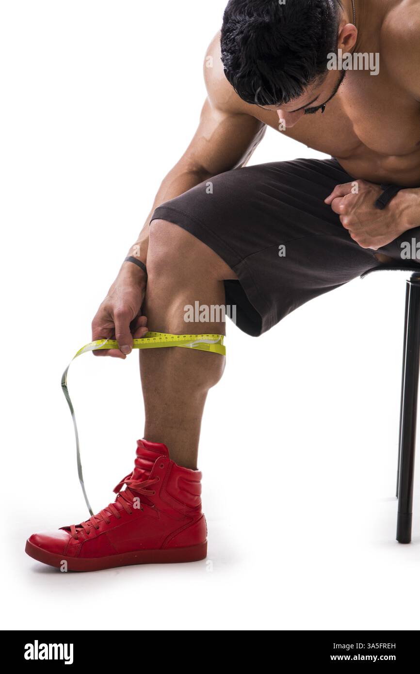 Muscular bodybuilder man measuring calf with tape measure, close-up ...