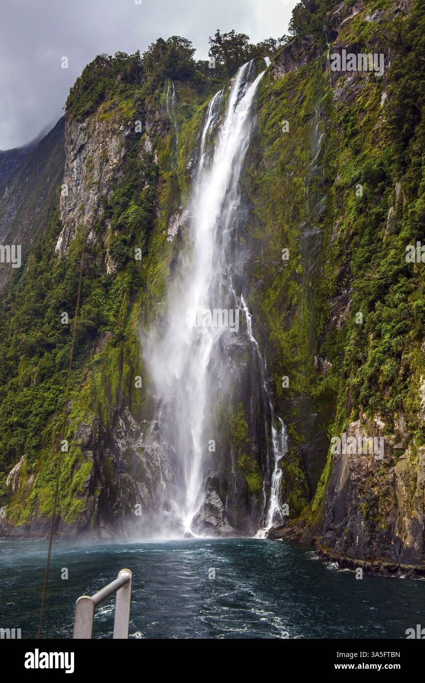 Magnificent waterfall crashes down from the cliff. Tourist cruise ...