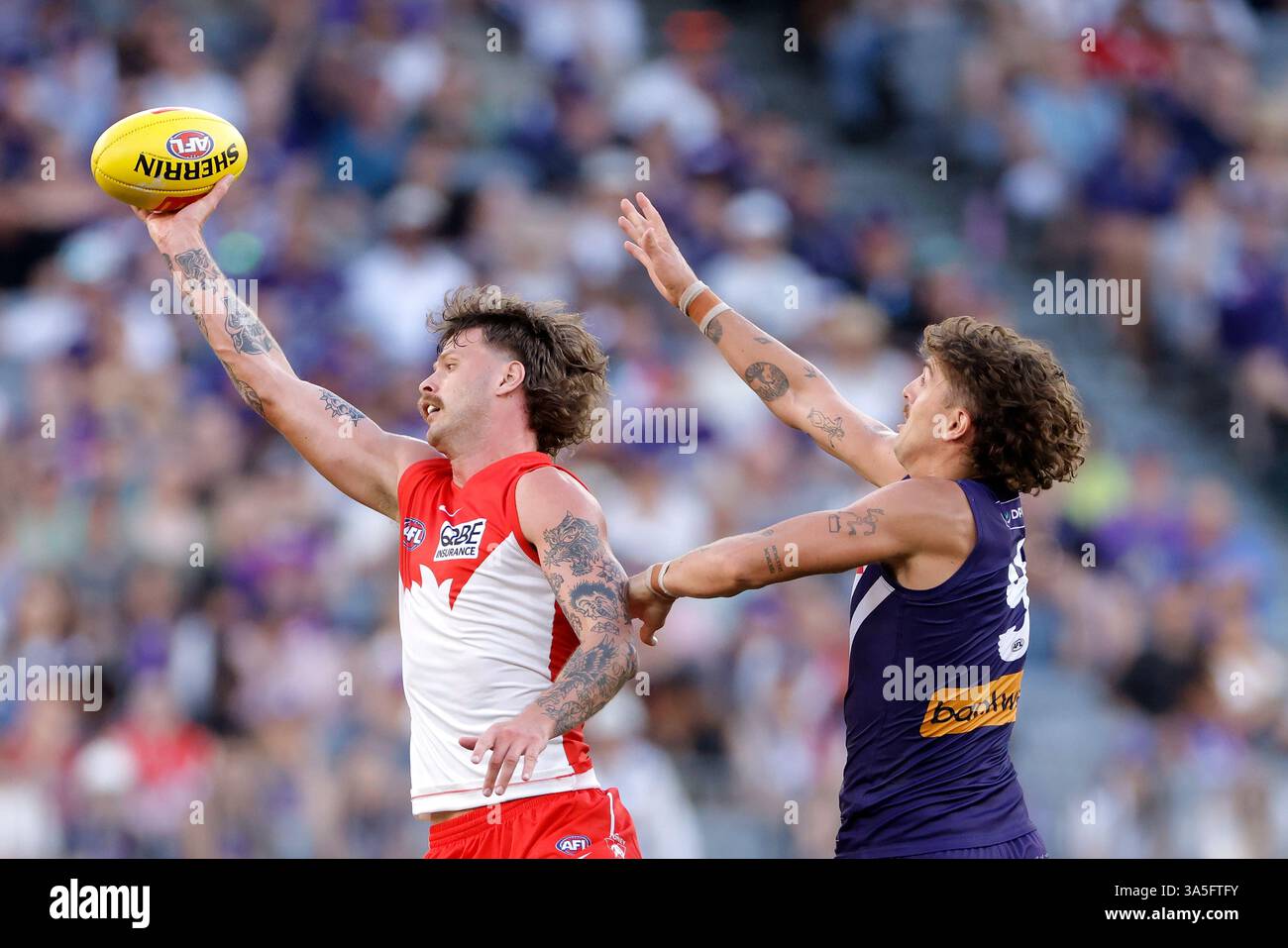 Perth, Australia. 23rd Mar, 2025. Peter Ladhams of the Swans and Luke ...