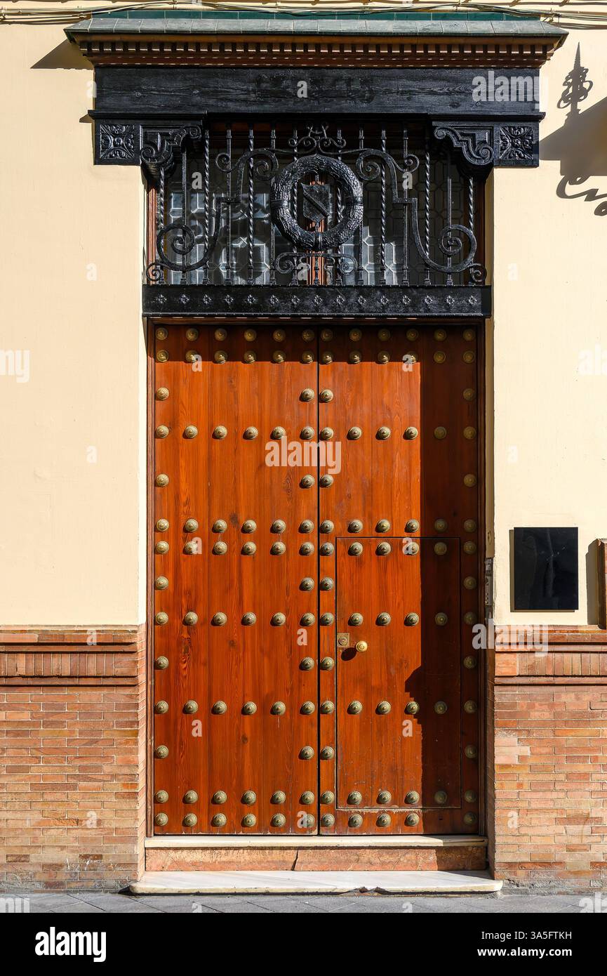 Ancient building entrance door with metalwork featuring a coat of arms ...