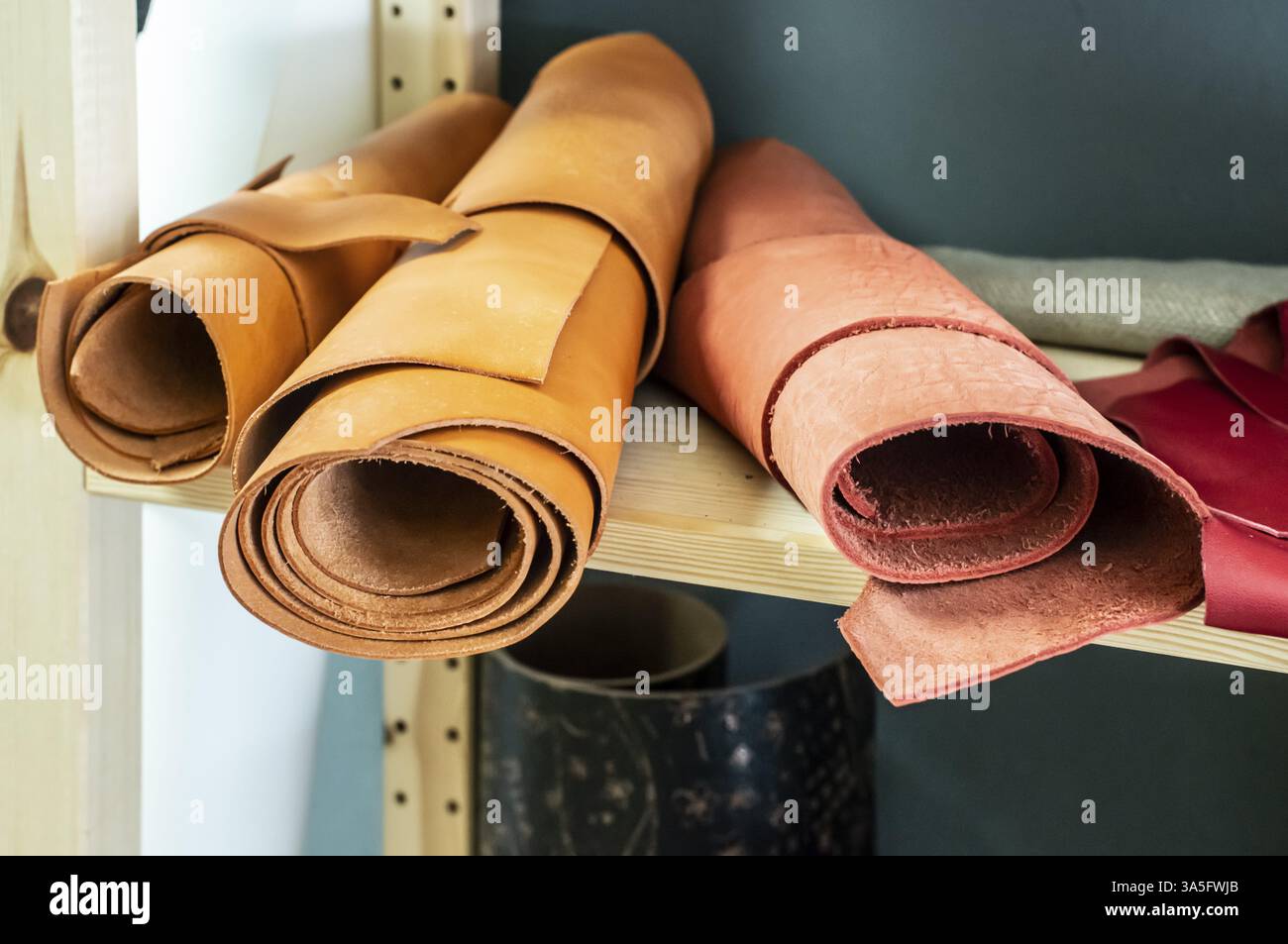 Many rolls leather on shelf in leather workshop Stock Photo - Alamy