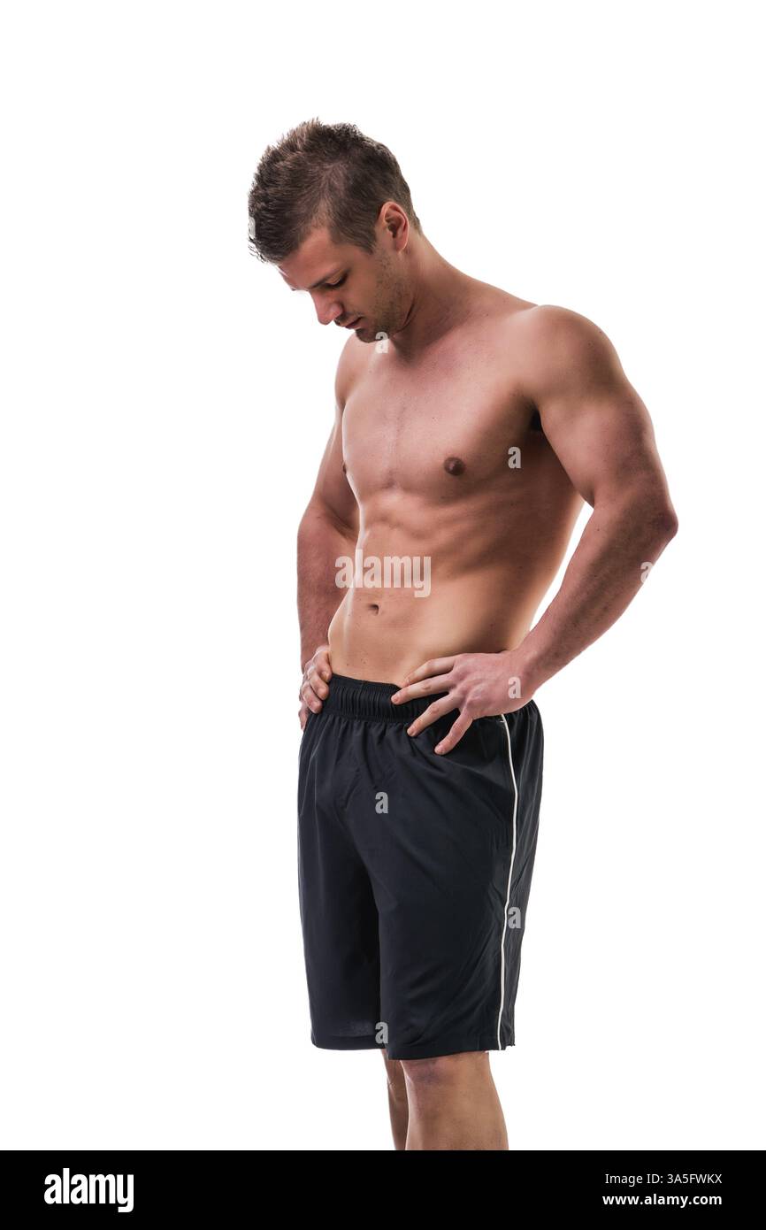 Handsome bodybuilder in relaxed pose, looking down, isolated on white ...