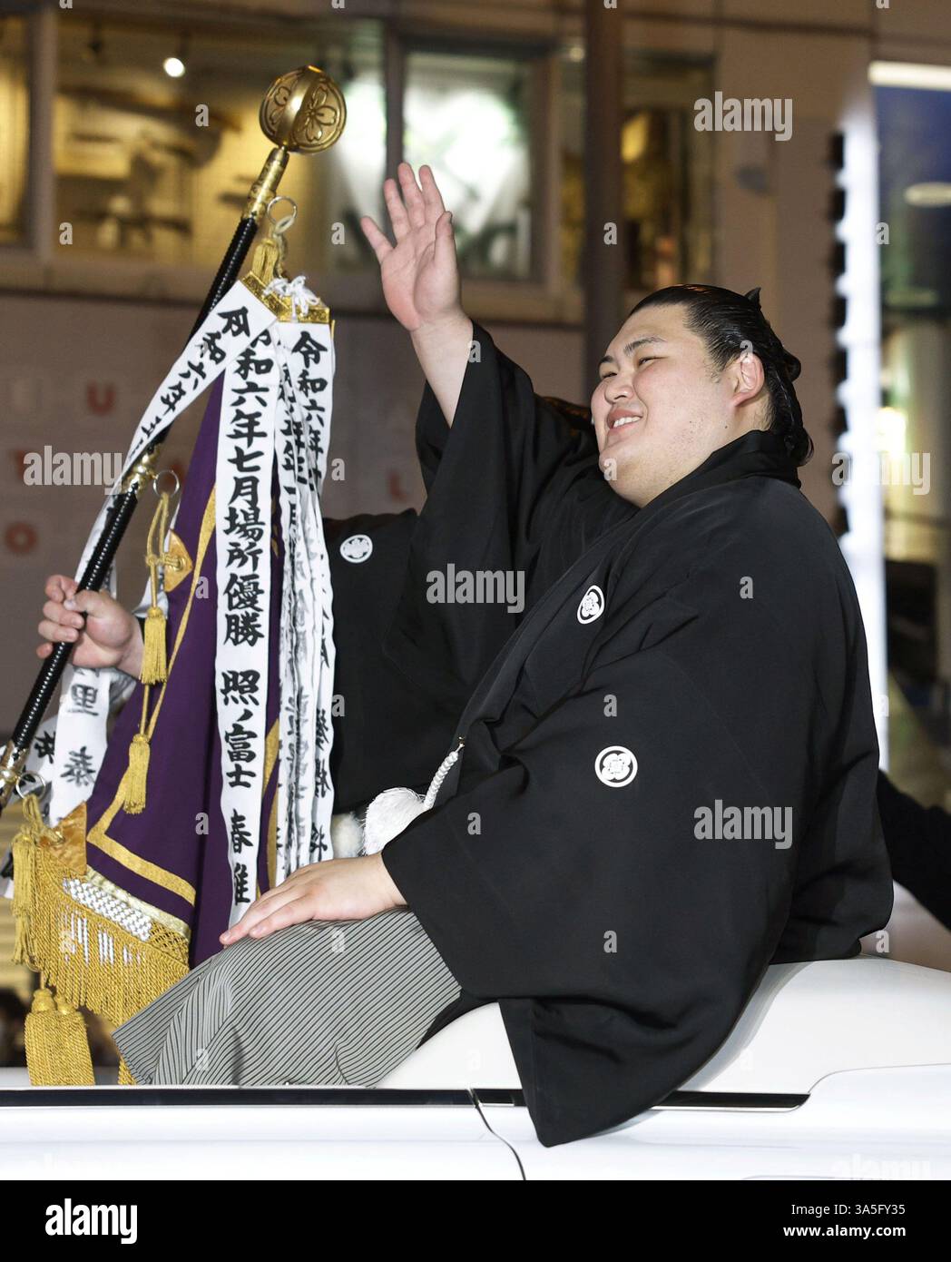 Ozeki Onosato waves to fans ahead of a parade being held after winning ...