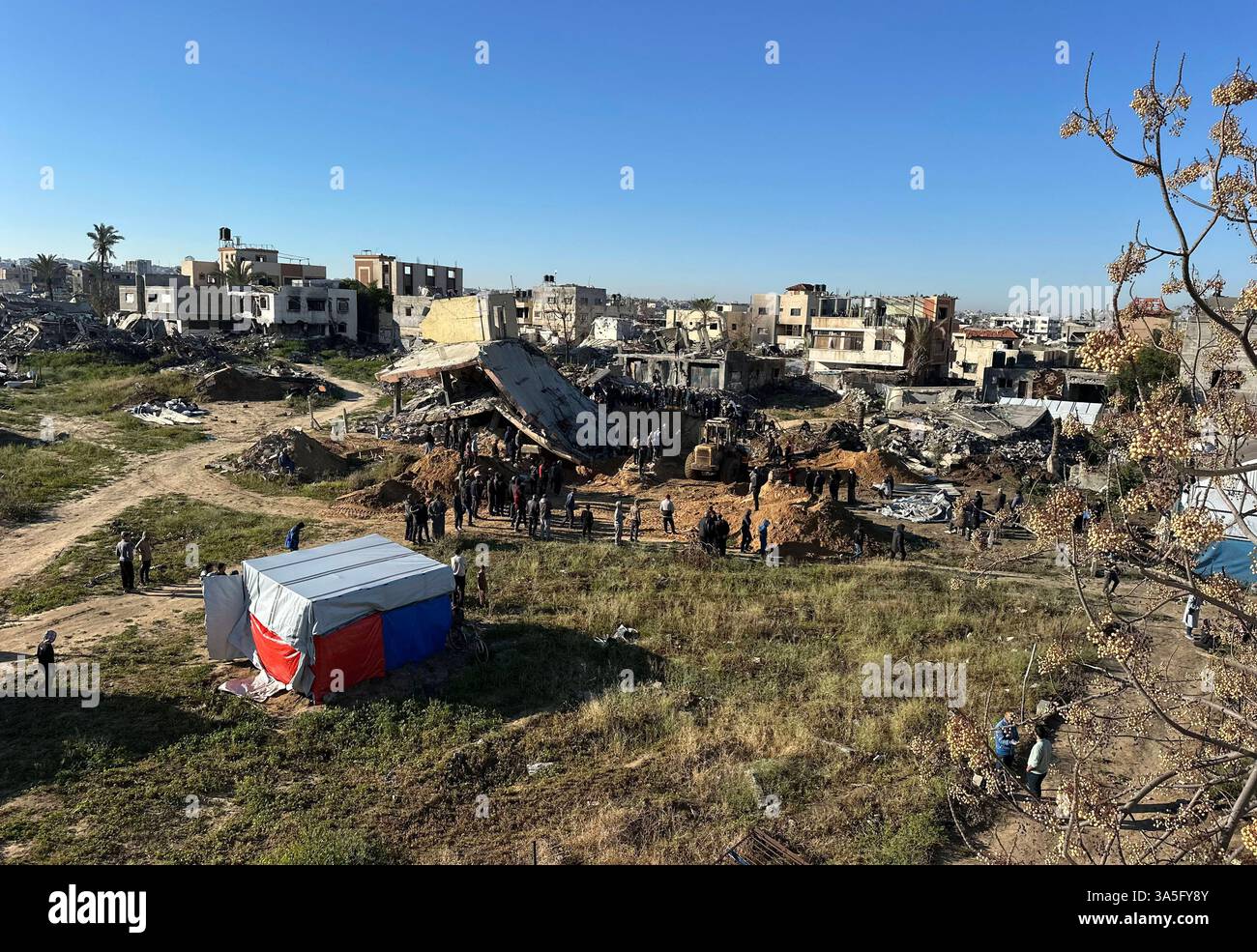 Palestinians search through the rubble of Agha family building at the ...
