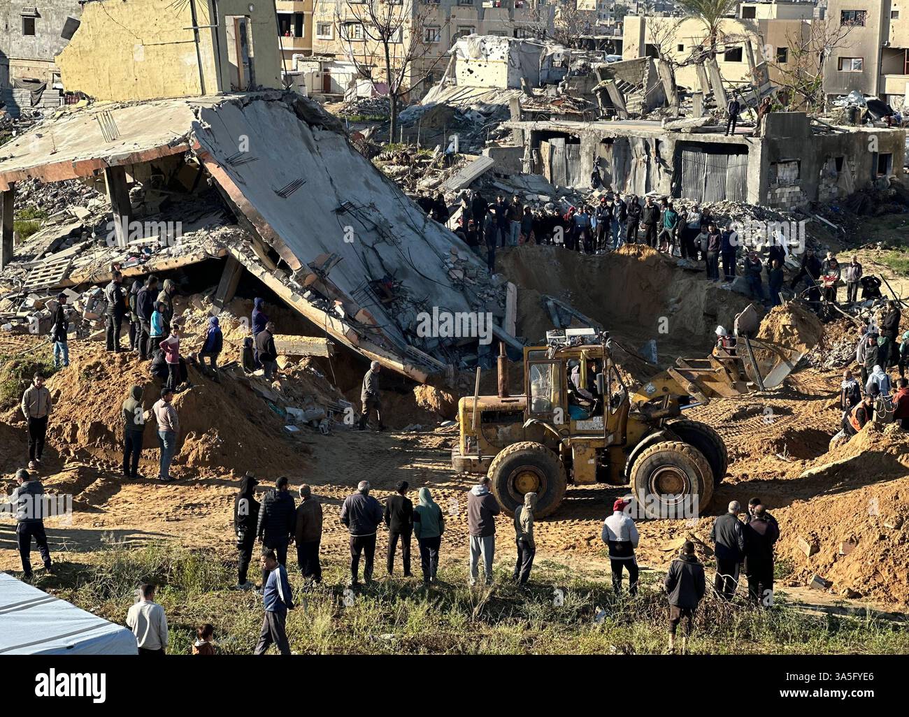 Palestinians search through the rubble of Agha family building at the ...