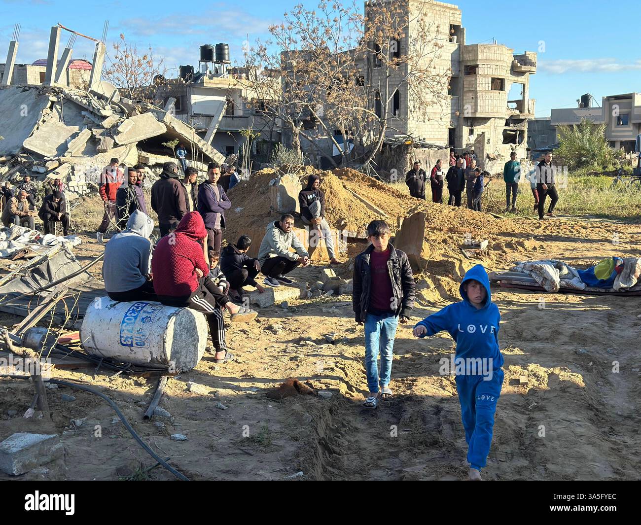 Palestinians search through the rubble of Agha family building at the ...