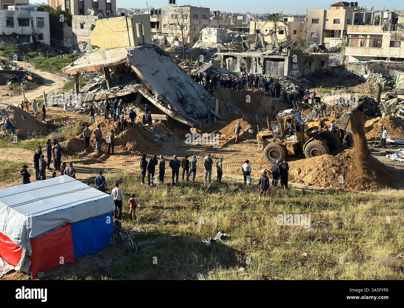 Palestinians search through the rubble of Agha family building at the ...