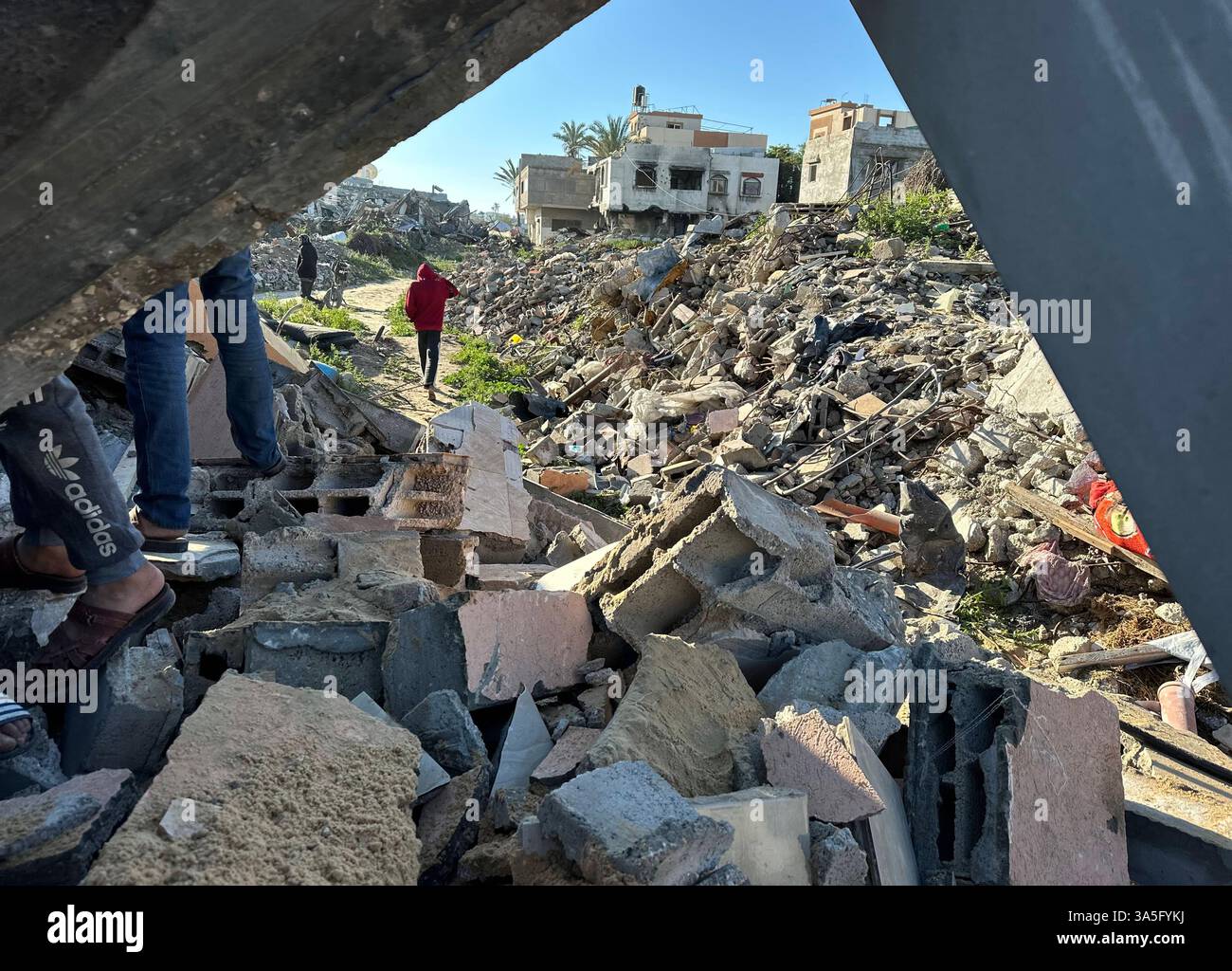 Palestinians search through the rubble of Agha family building at the ...