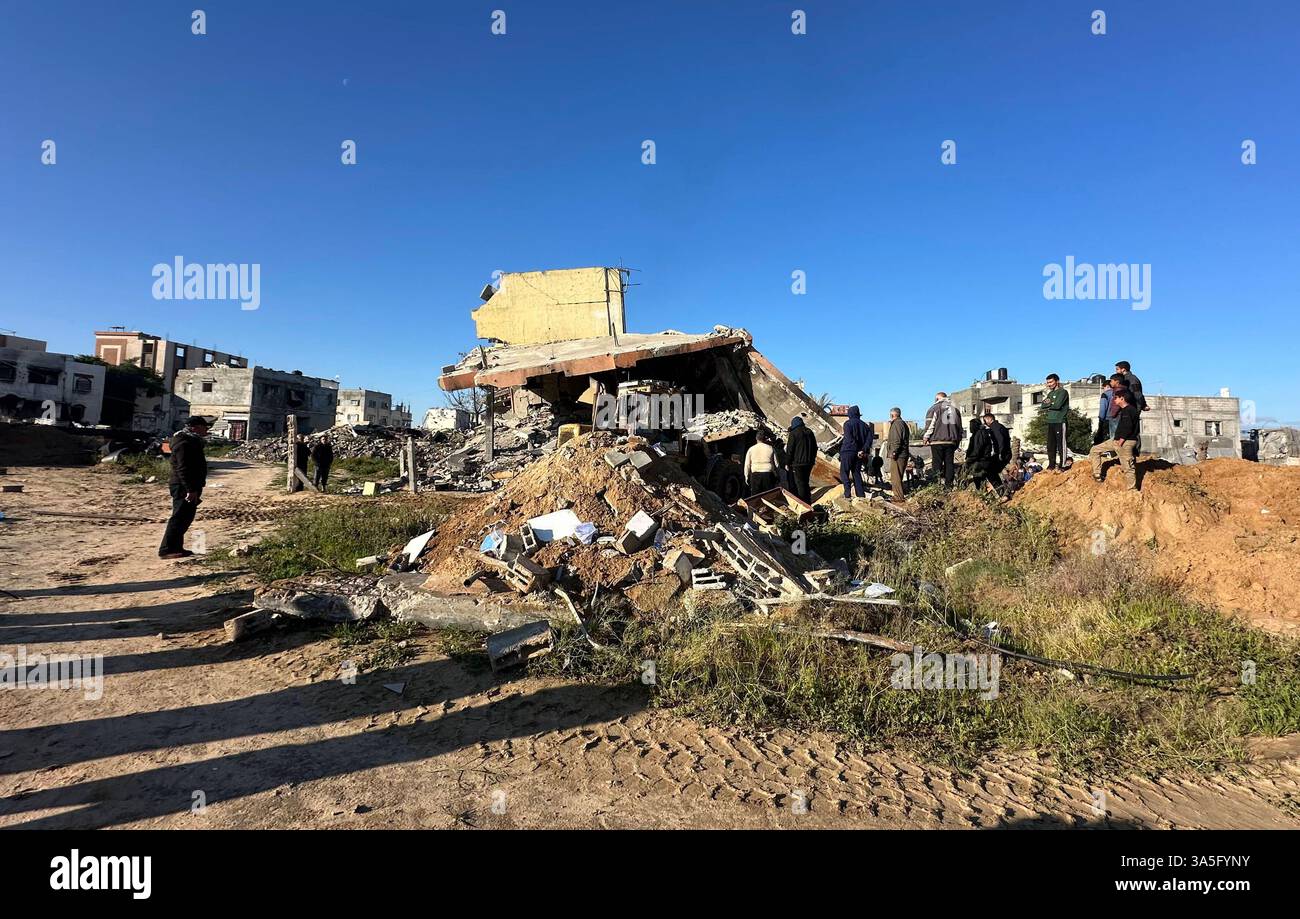 Palestinians search through the rubble of Agha family building at the ...