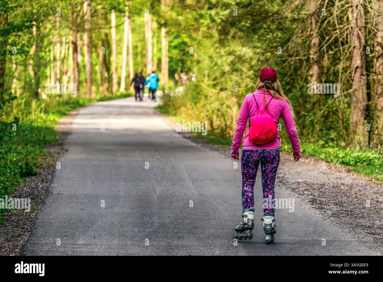 Skating on roller blades in spring forest at asphalt road. Gaderska ...