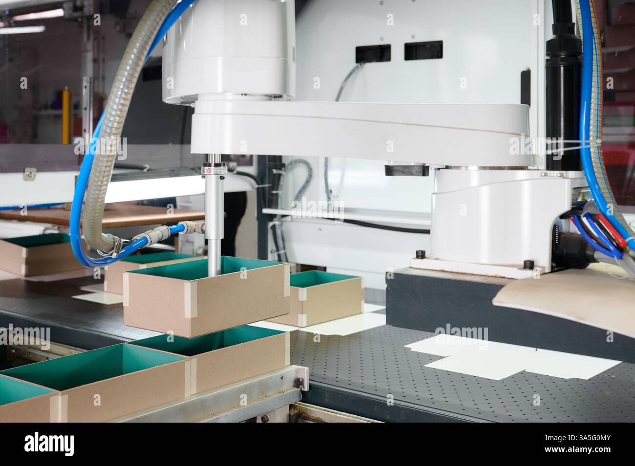 Robotic arms sorting decorative boxes on an efficient conveyor system ...