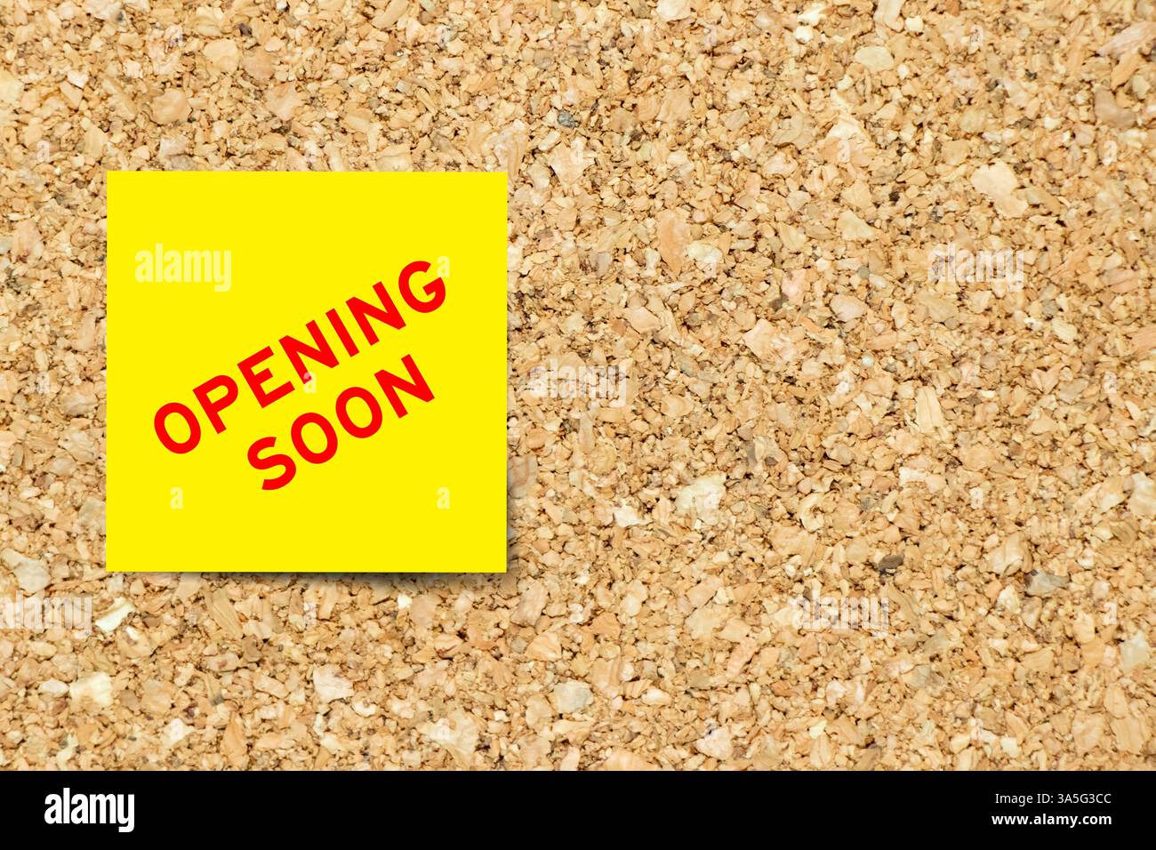 Yellow note paper with word opening soon on cork board background with ...