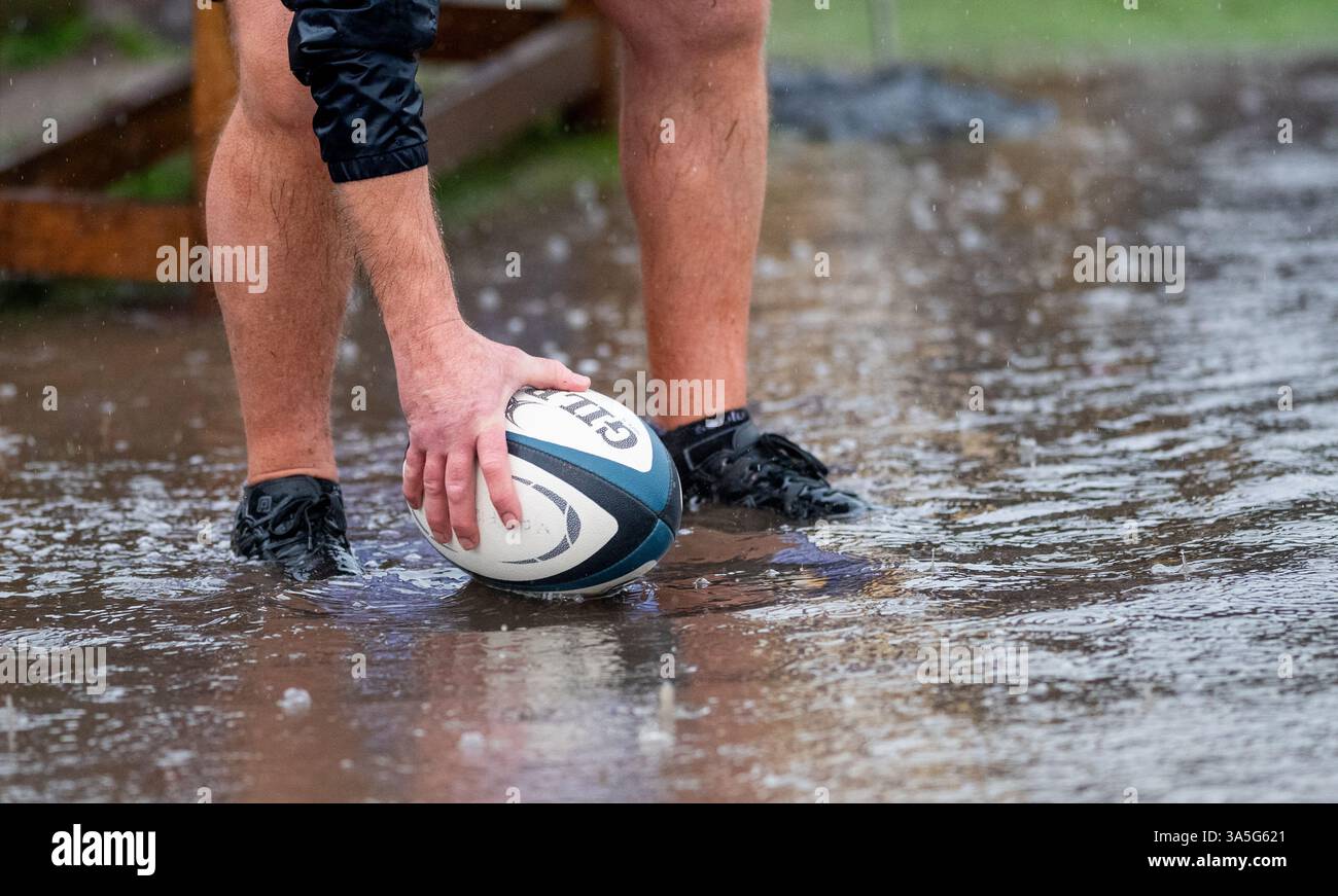Retrieving a rugby ball from a puddle during a mens amateur Rugby Union ...