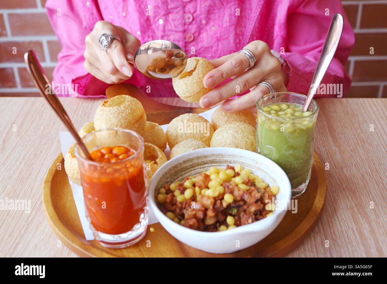 Woman breaking the hollow shell of Pani Puri, an Indian snack served ...