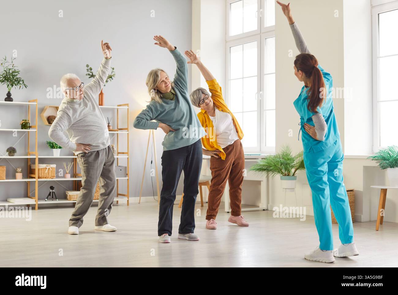 Group of seniors doing healthy stretching exercises for wellness and ...