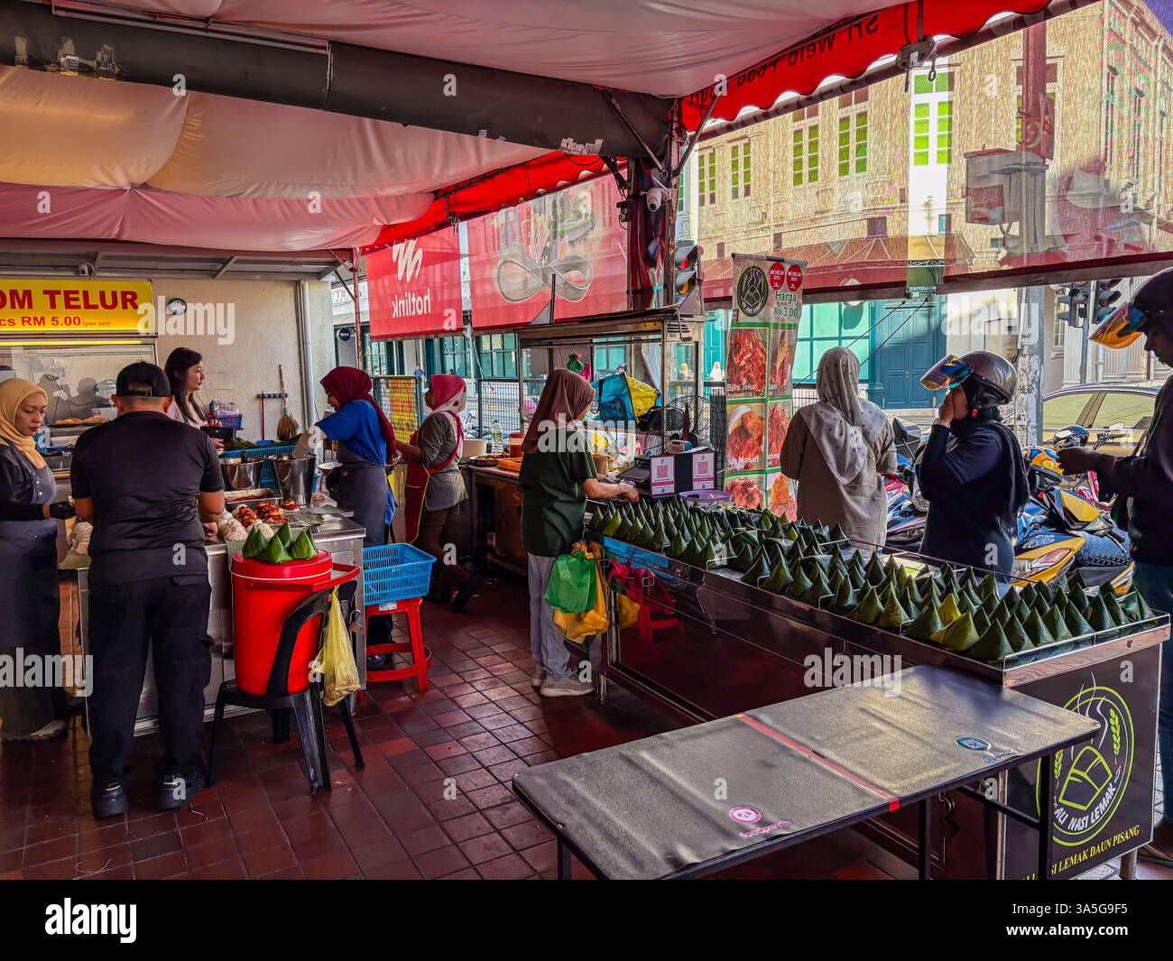 People ordering Nasi Lemak at a busy stall. Pre-made food wrapped in ...