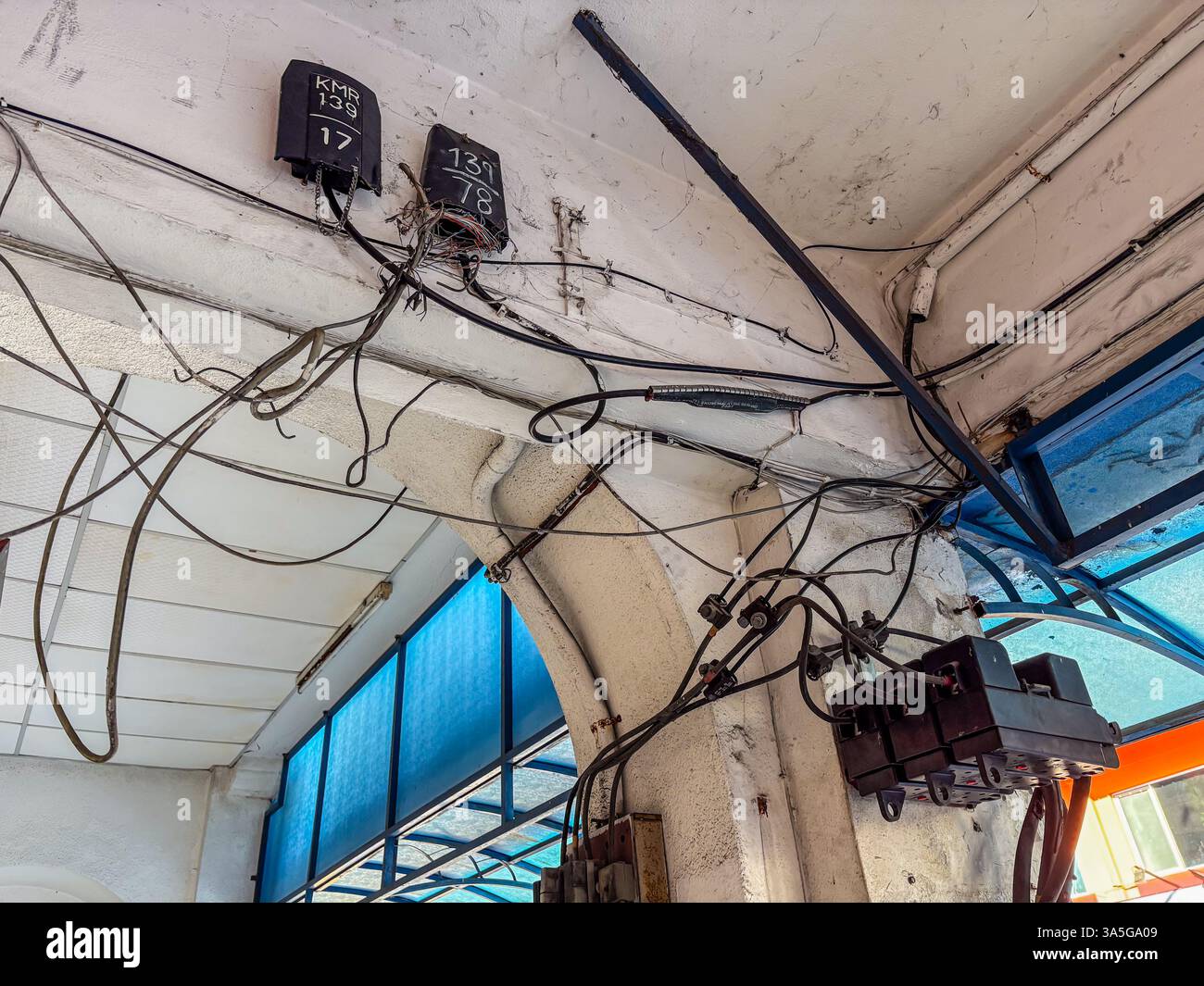 Mess of tangled electrical wires and junction boxes on a ceiling in ...