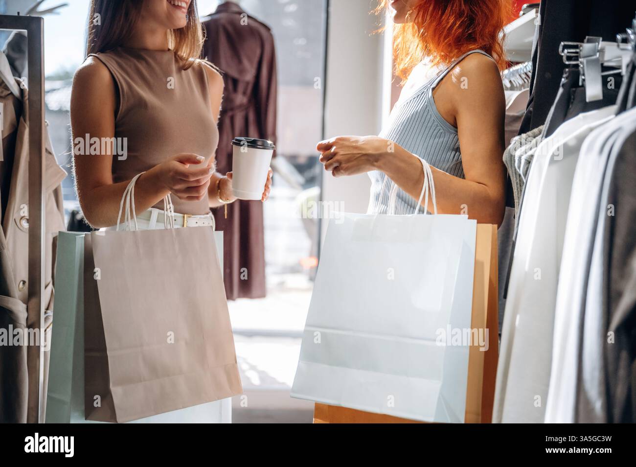 Casual conversation, with drink. Two female friends are in the retail ...