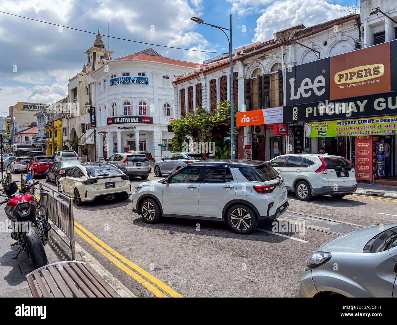 Cars navigate the busy streets in George Town, Penang, Malaysia ...