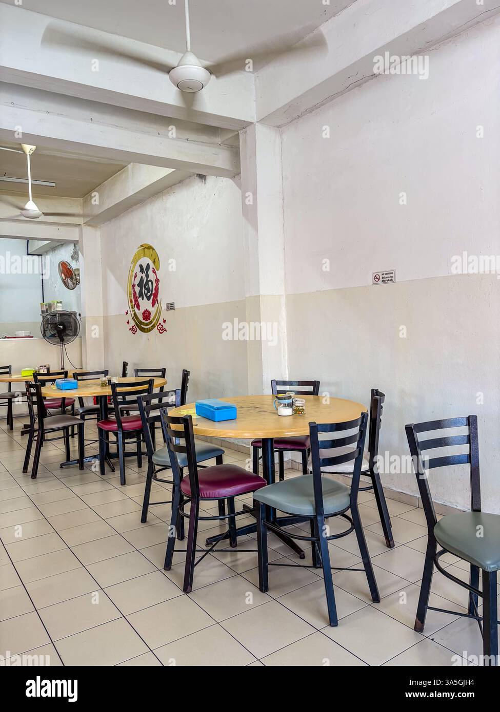 The interior of a kopitiam in Malaysia. Showing chairs, round tables ...