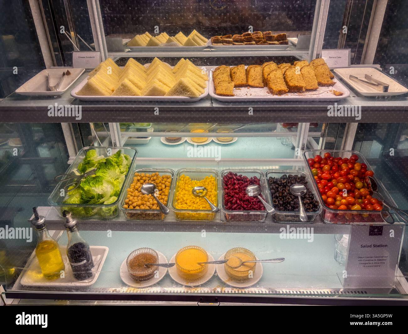 A refrigerated food display case contains cheese sandwiches, banana ...