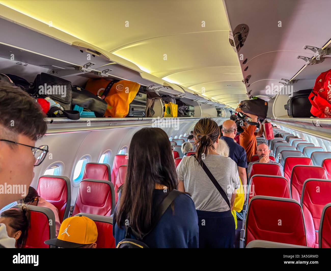 Passengers in AirAsia airplane's aisle are boarding to their seats ...
