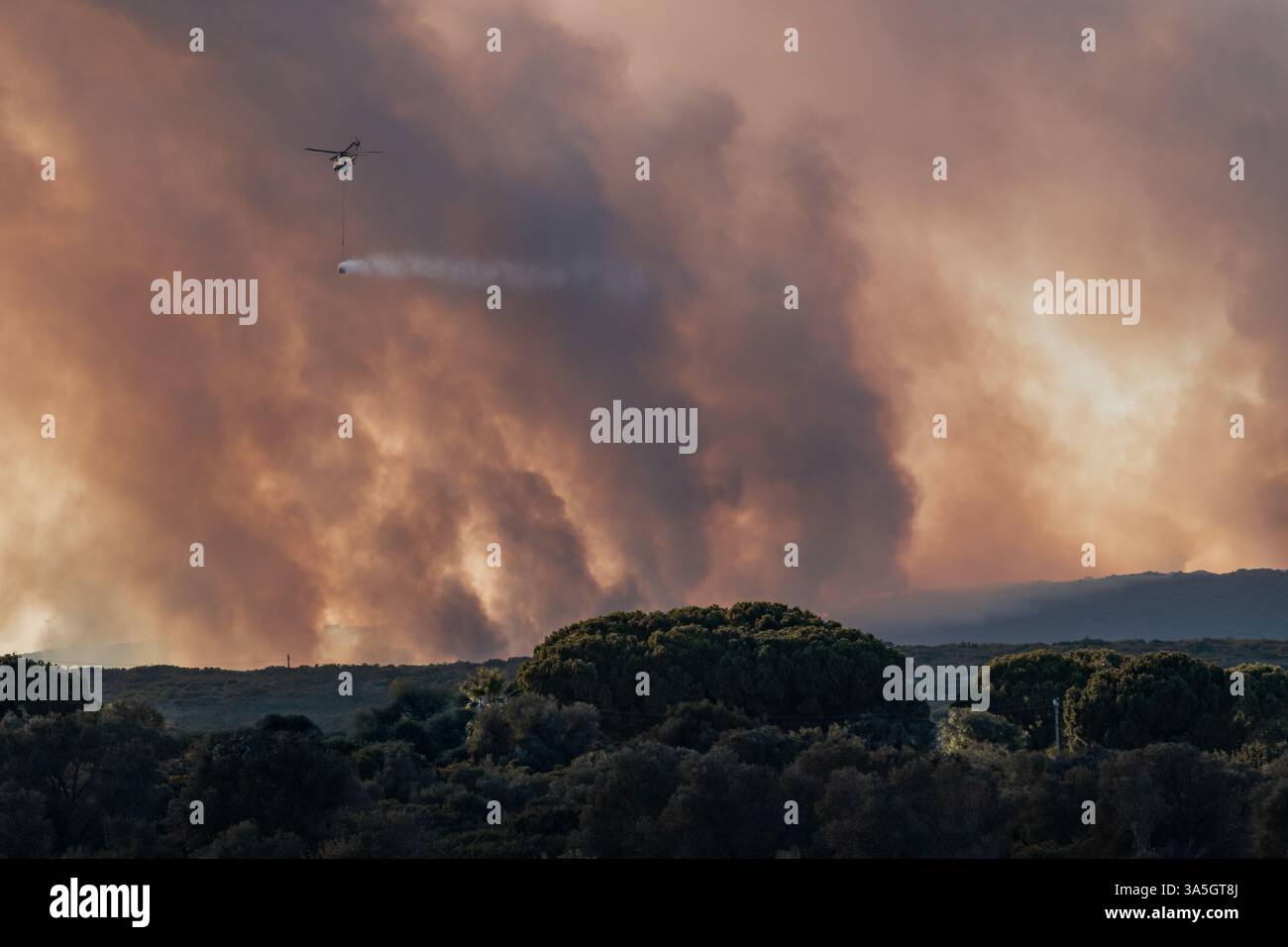 Helicopter releases water during wildfire containment effort amid thick ...