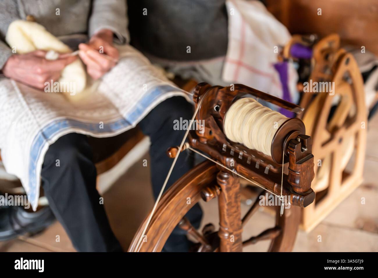 Gutach, Germany. 23rd Mar, 2025. A man spins yarn with a spindle in a ...