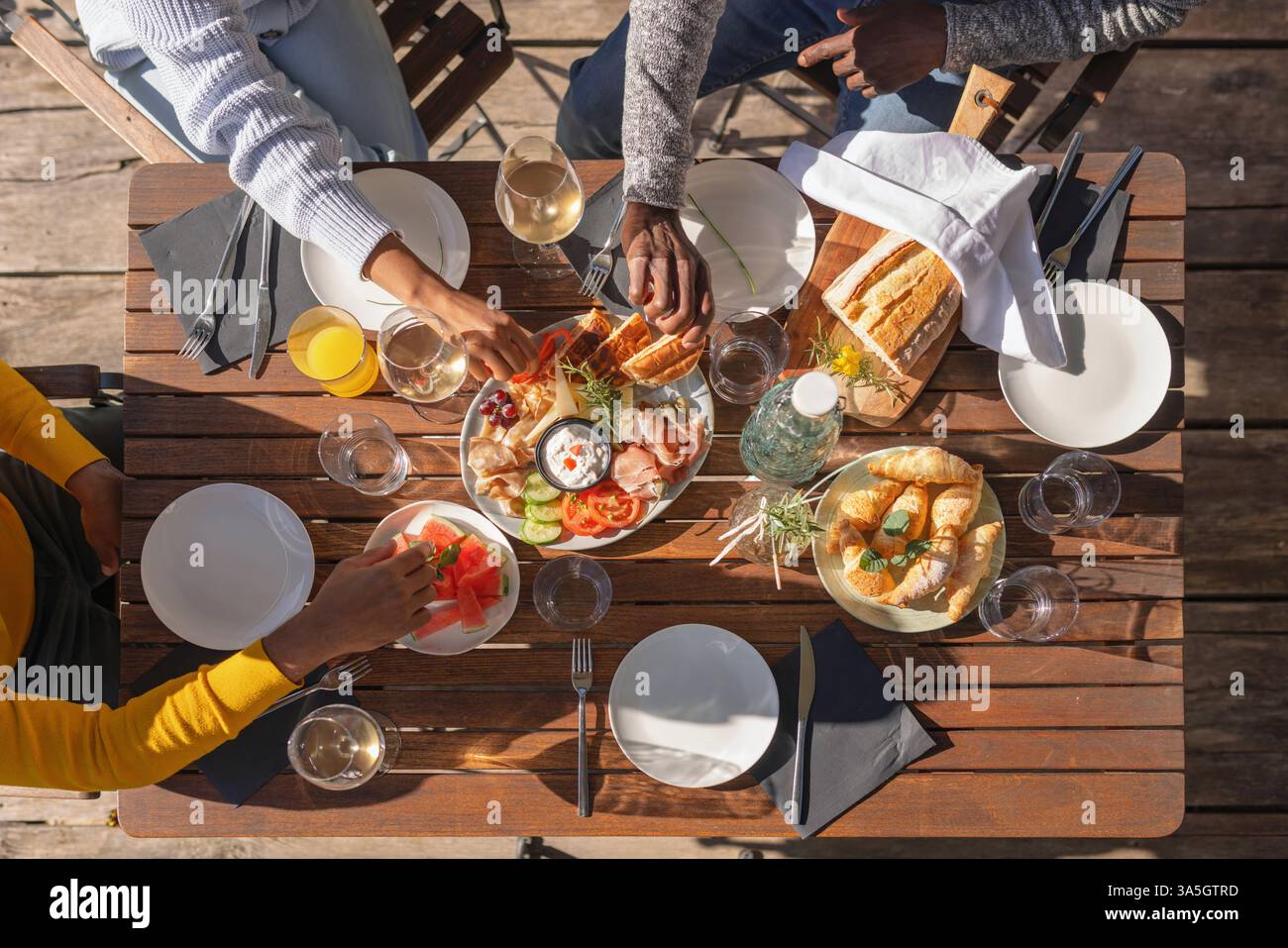 Friends enjoying their vacation, eating lunch outdoor terrace of a ...